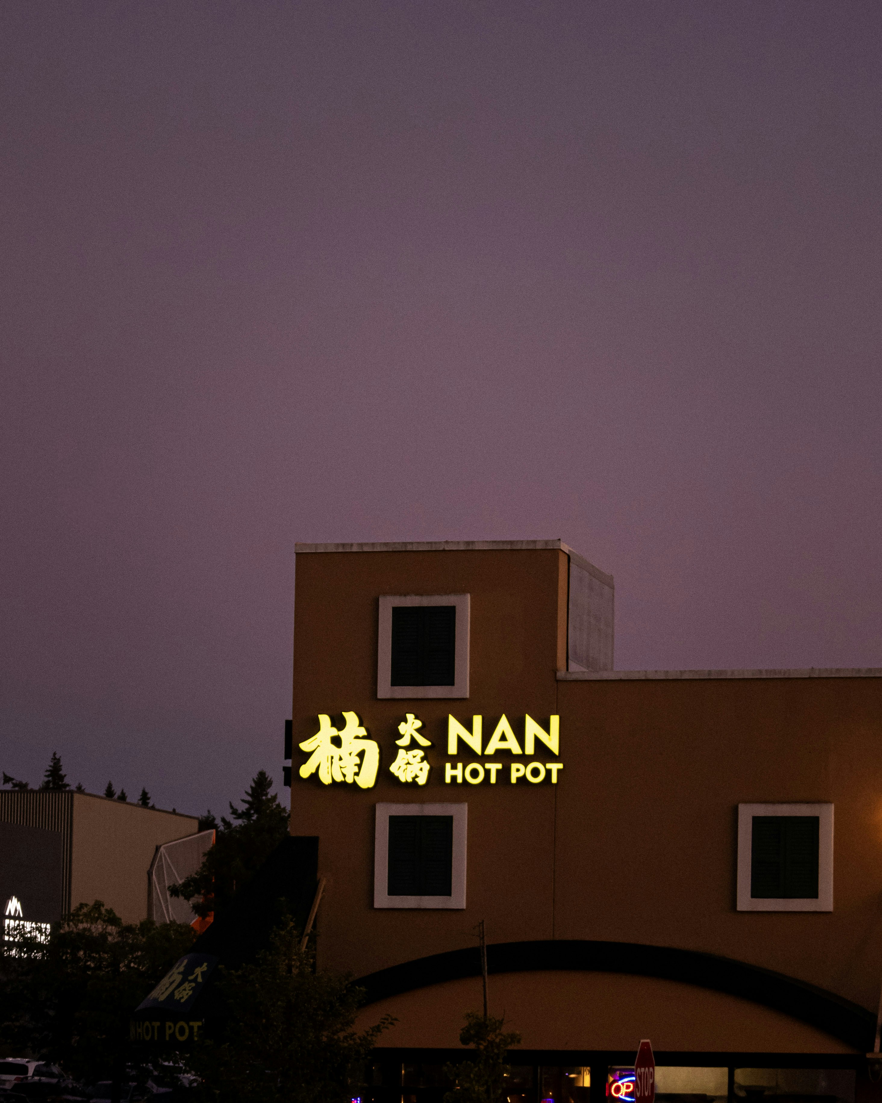 Neon Sign at Dusk: Hot Pot Restaurant Illuminates a Quiet Urban Corner