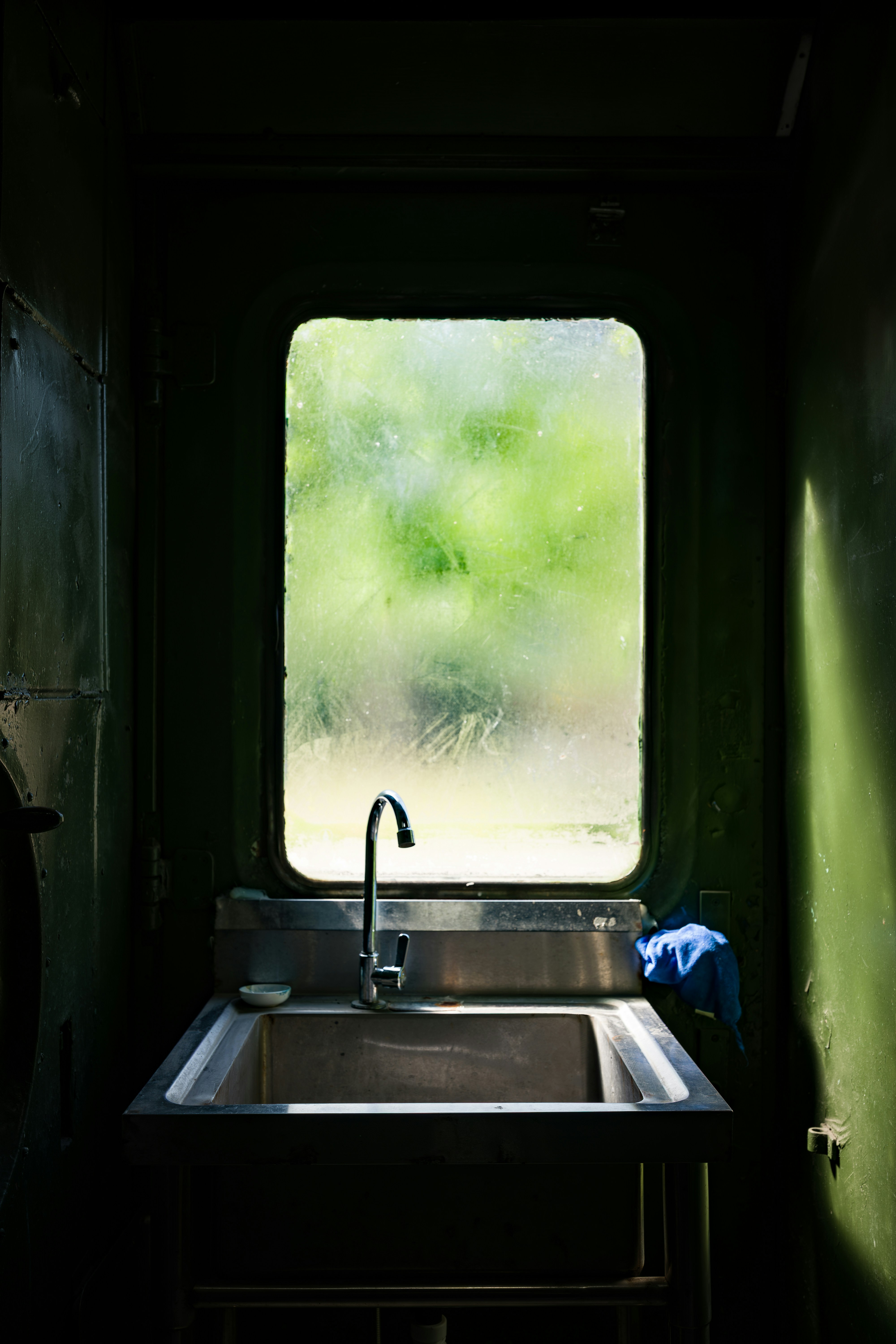 Urban Sink, Quiet Light: A Glimpse of a Dim Kitchen in a Moving Train