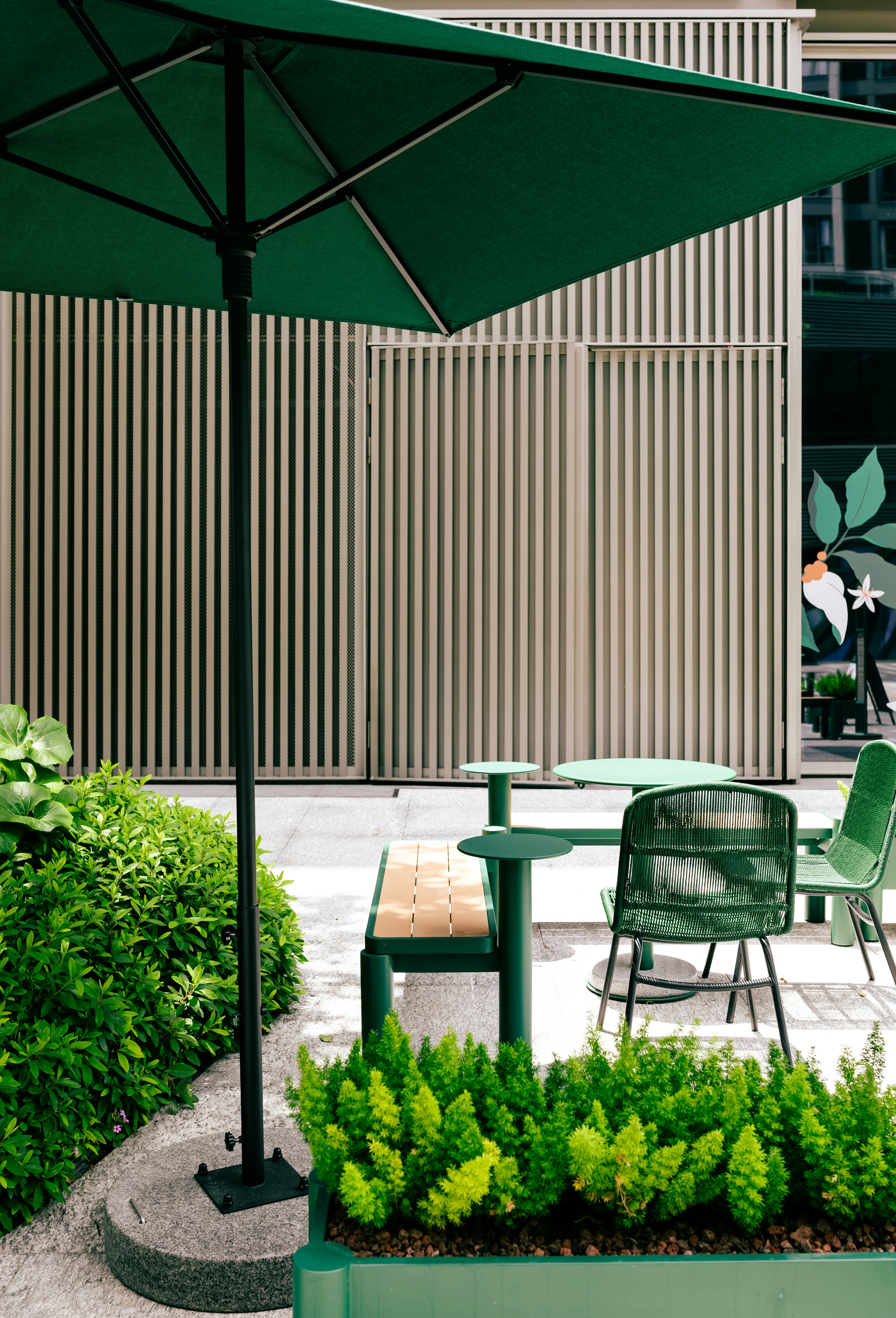 Shade and Steel: Outdoor Seating Under a Green Canopy