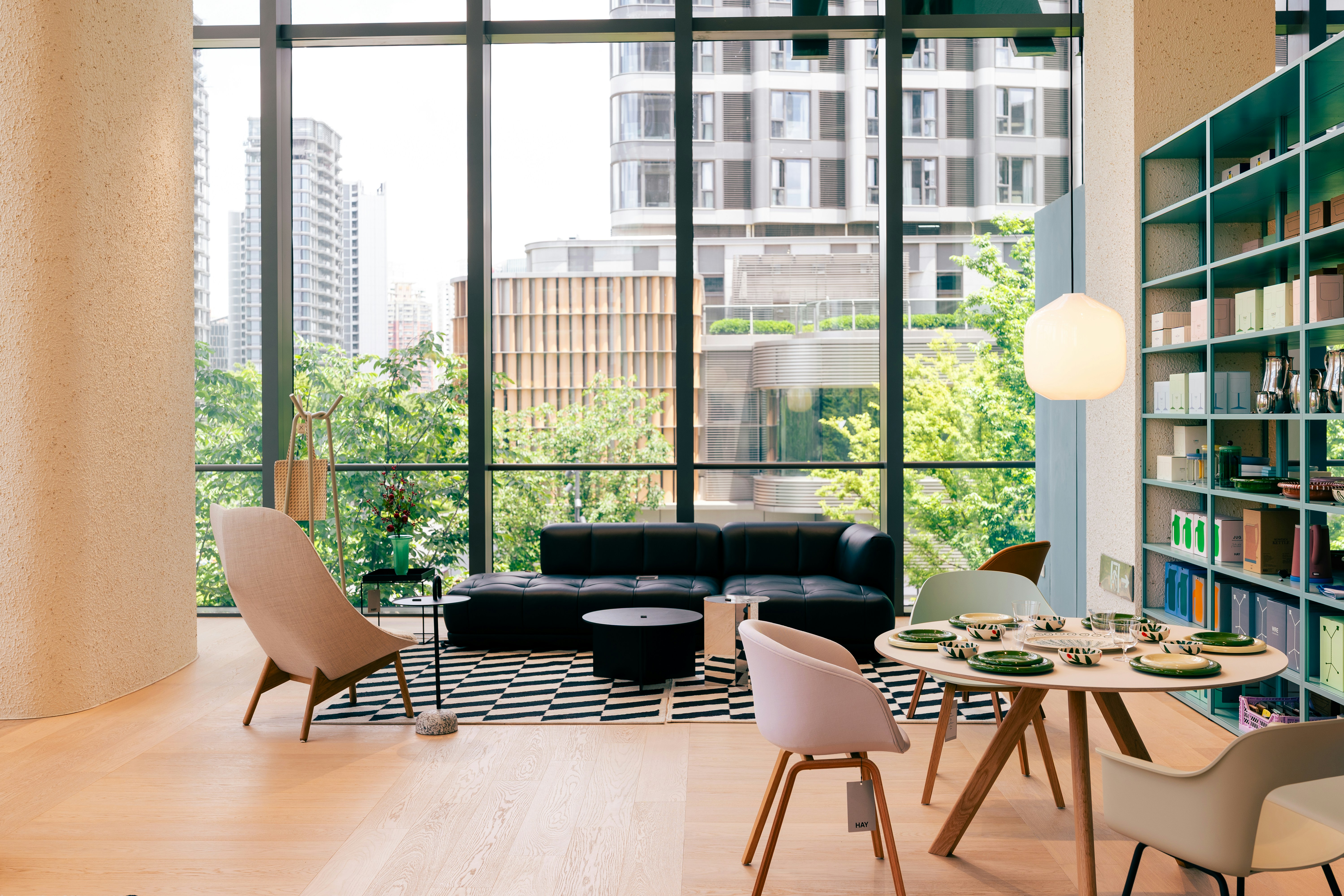 Sunlit lounge with floor-to-ceiling windows and a curated mid-century dining nook