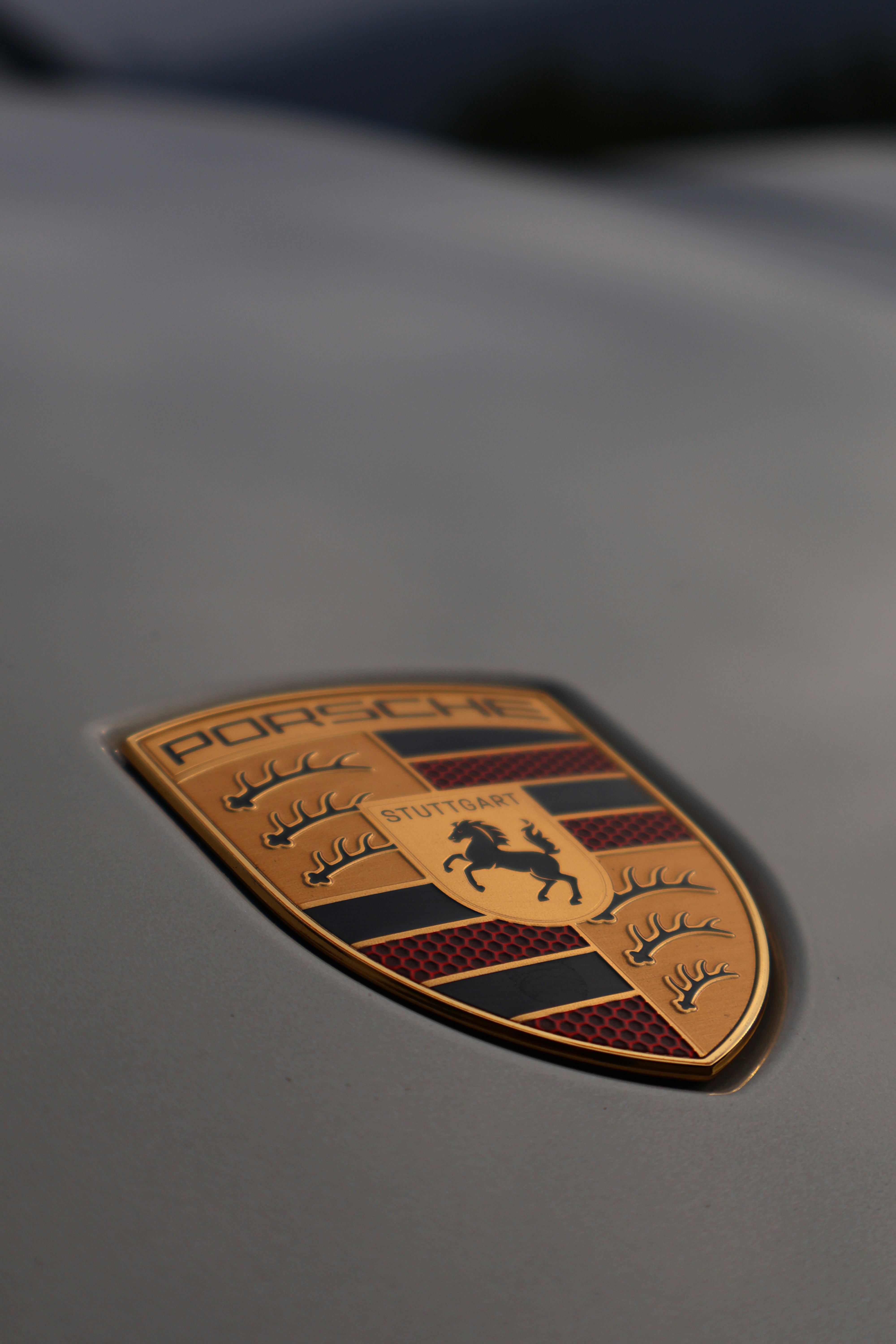 Emblem in Focus: Porsche Crest Anchored on a Metallic Surface