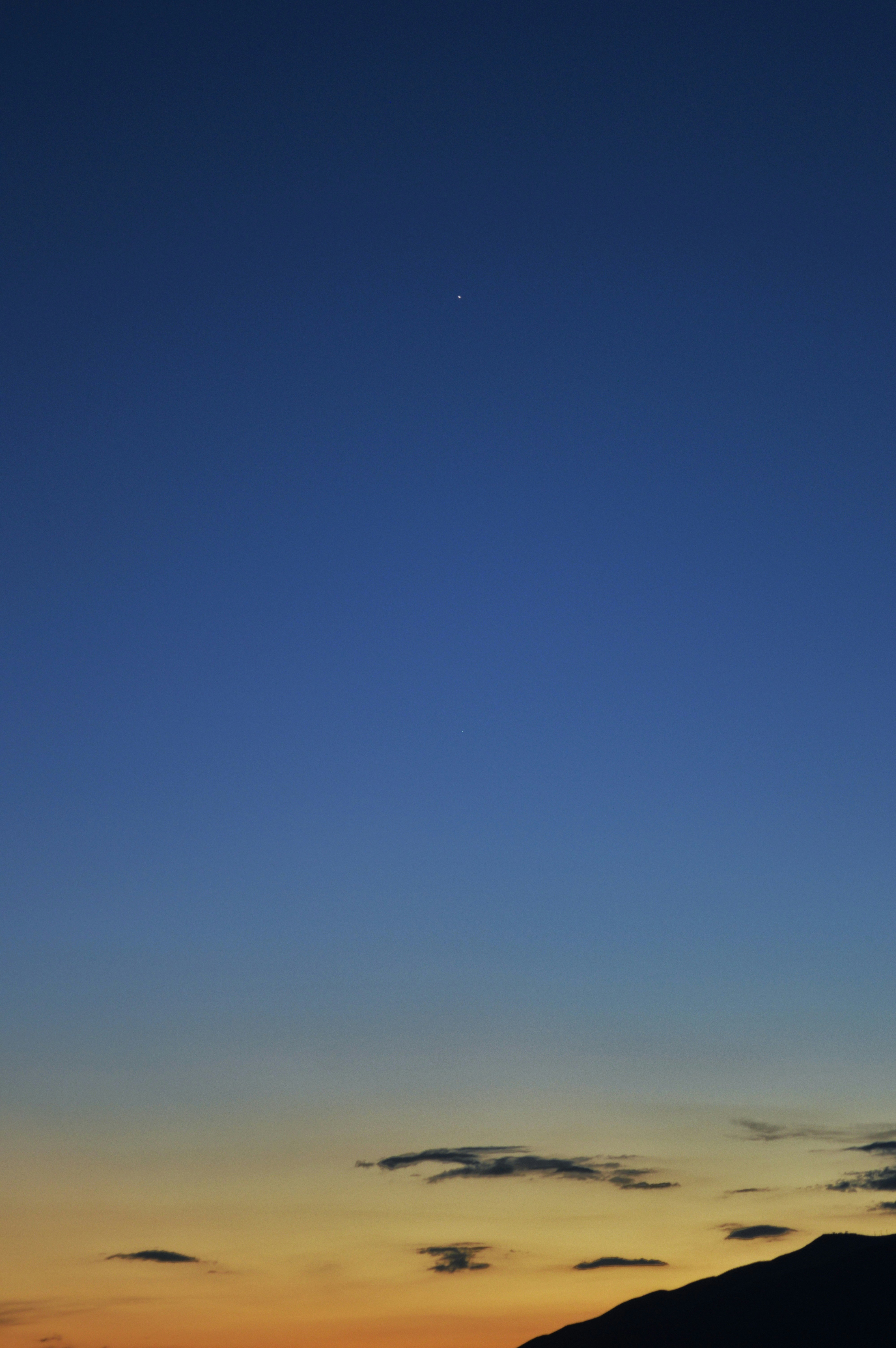 Dawn's Quiet Edge: A Mountain Silhouette Below a Clear Gradient Sky
