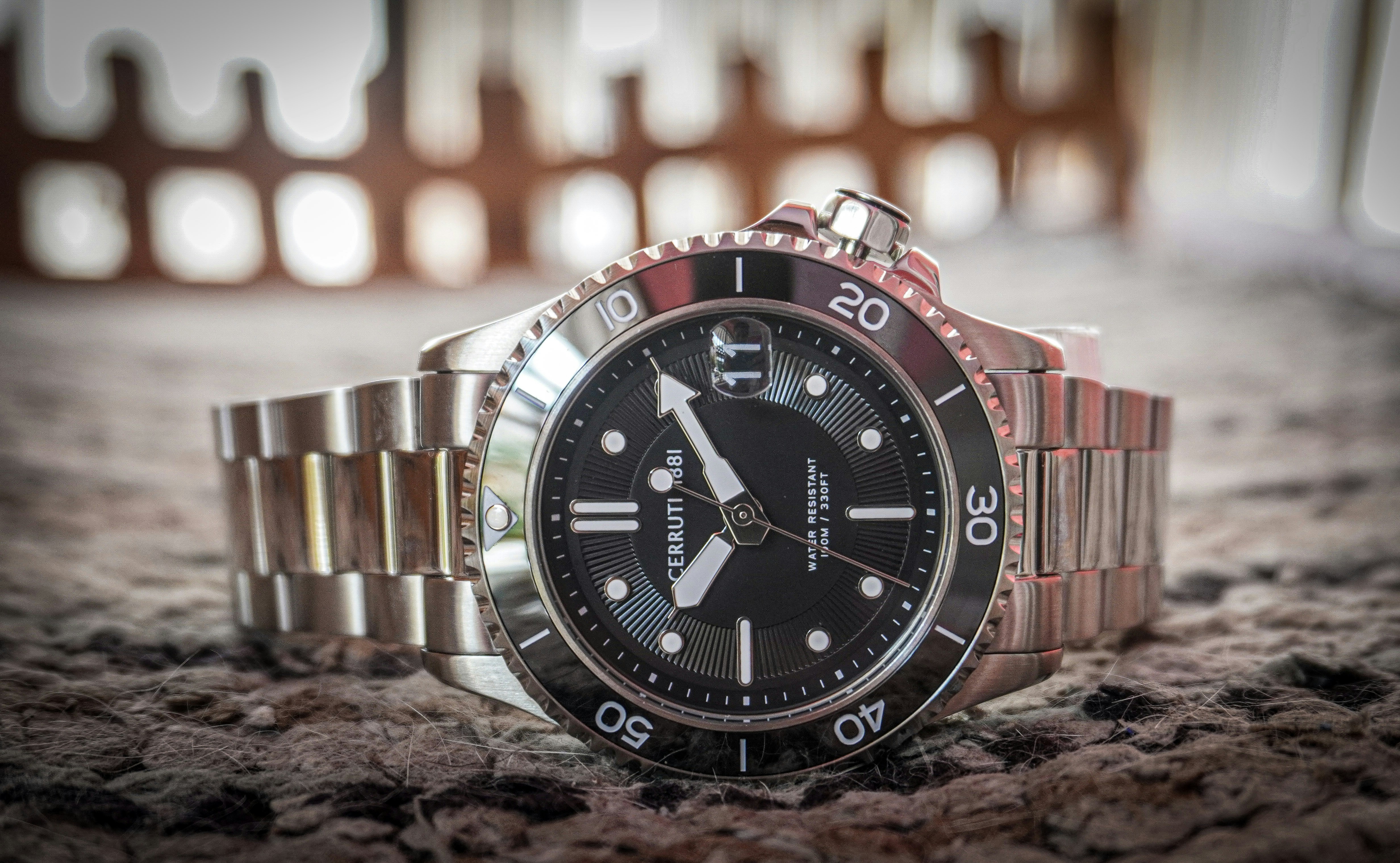 Metallic Timekeeper Resting on Marble: A Close-Up of a Diver's Watch