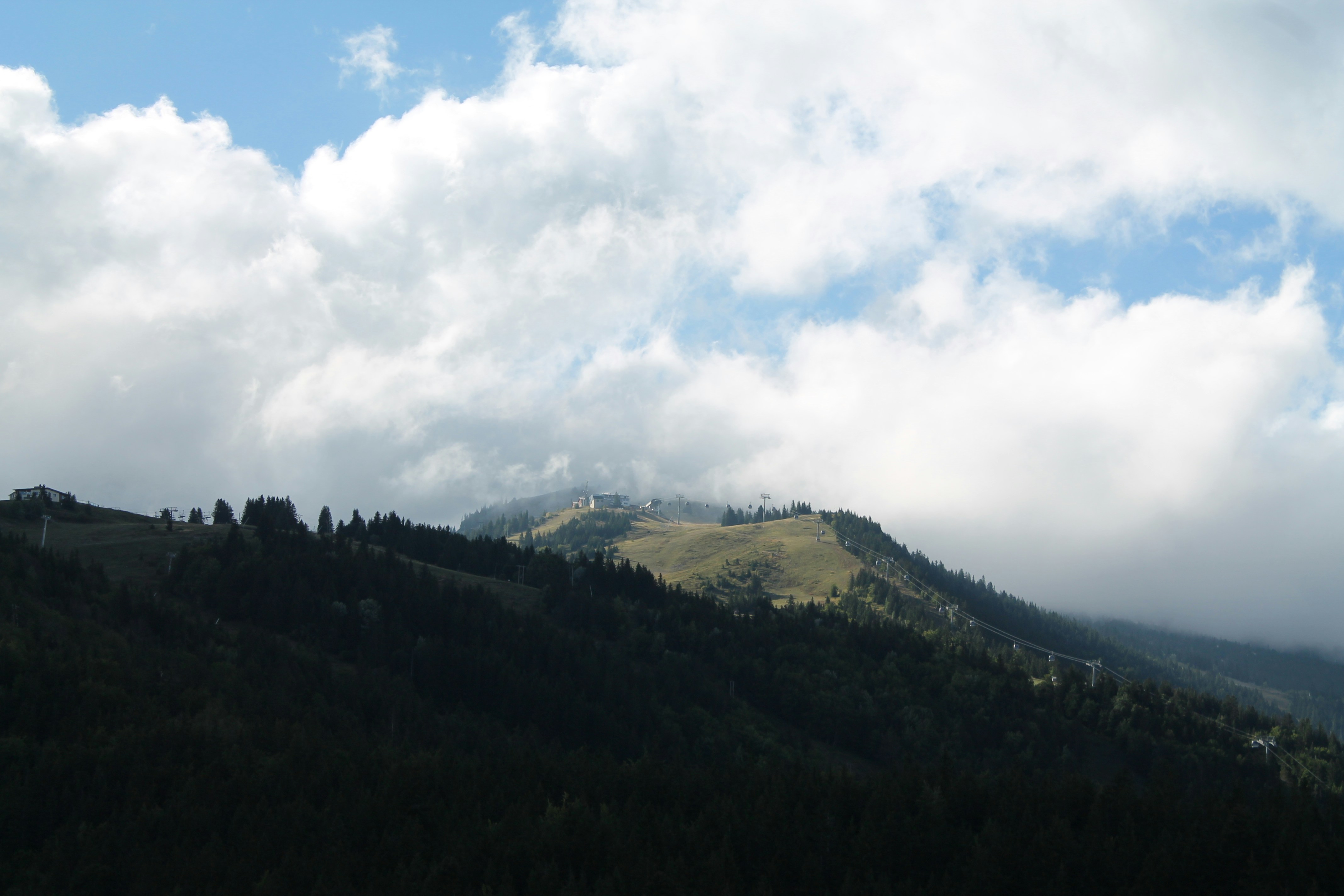 Sunlit Crest: A Mountain Meadow Breaks Through the Cloud Line