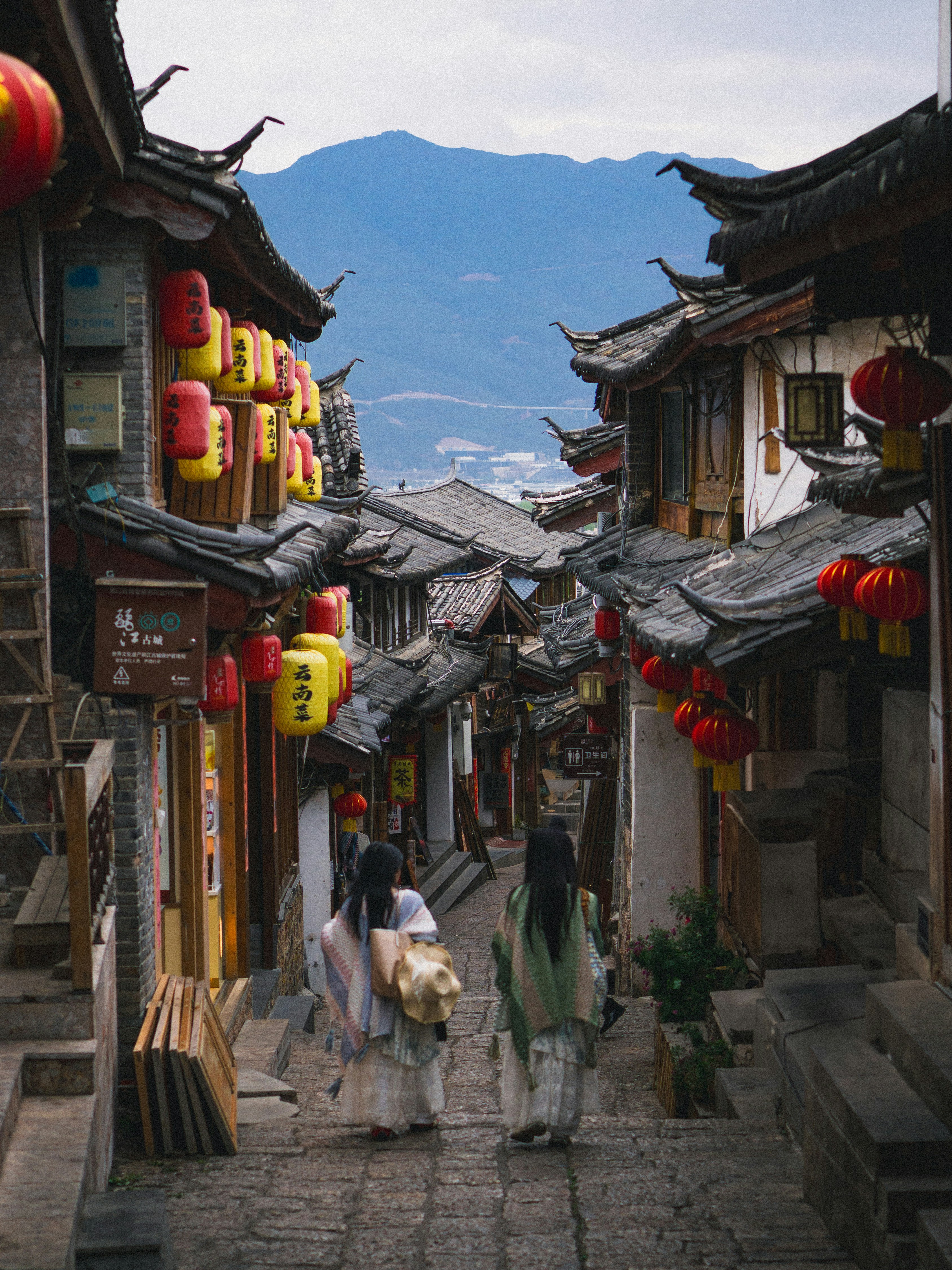 Lantern-lit Alley: Travelers in a Mountain Village