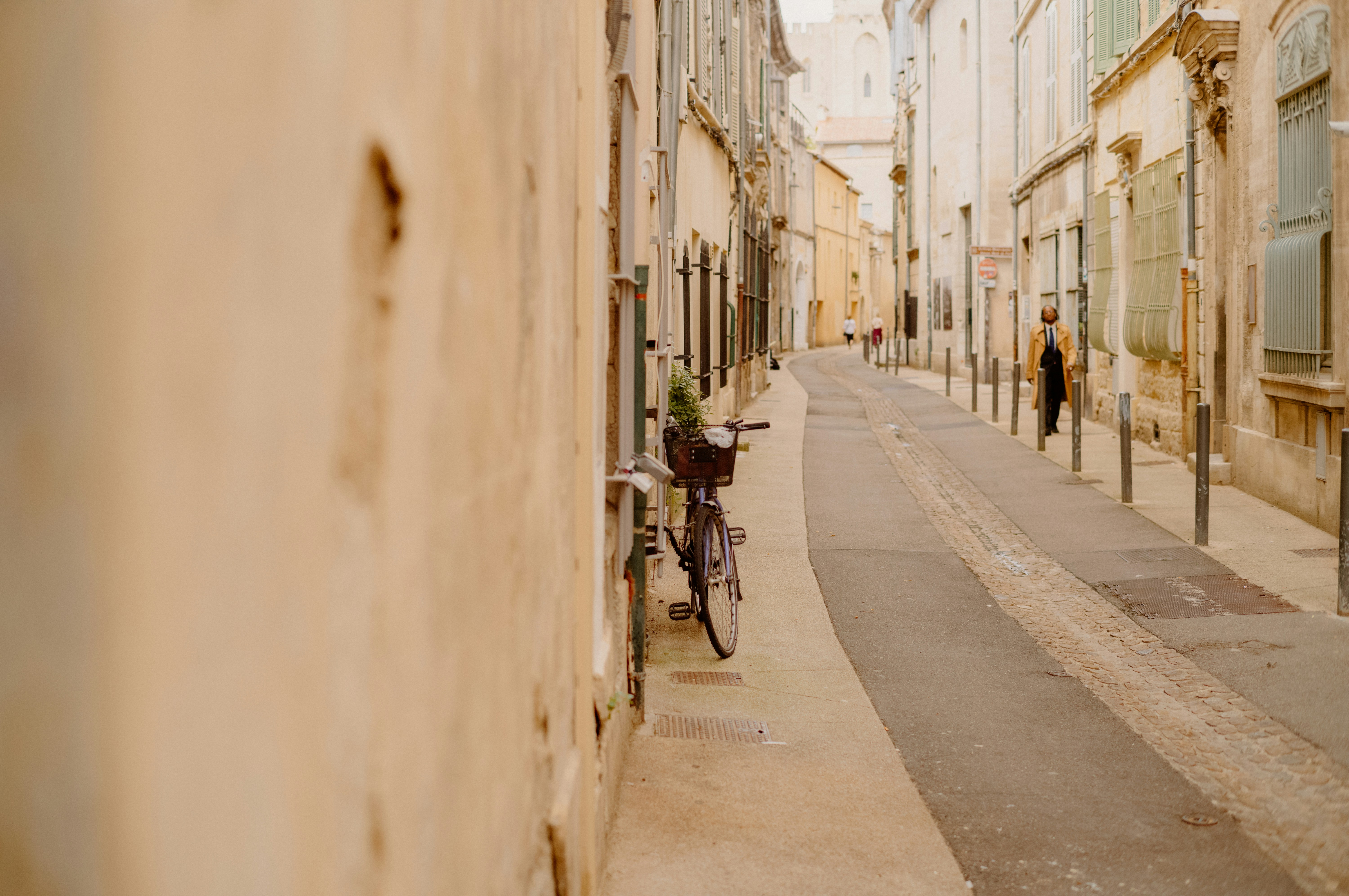 Narrow European Street: Bike, Pedestrians, and Warm Light