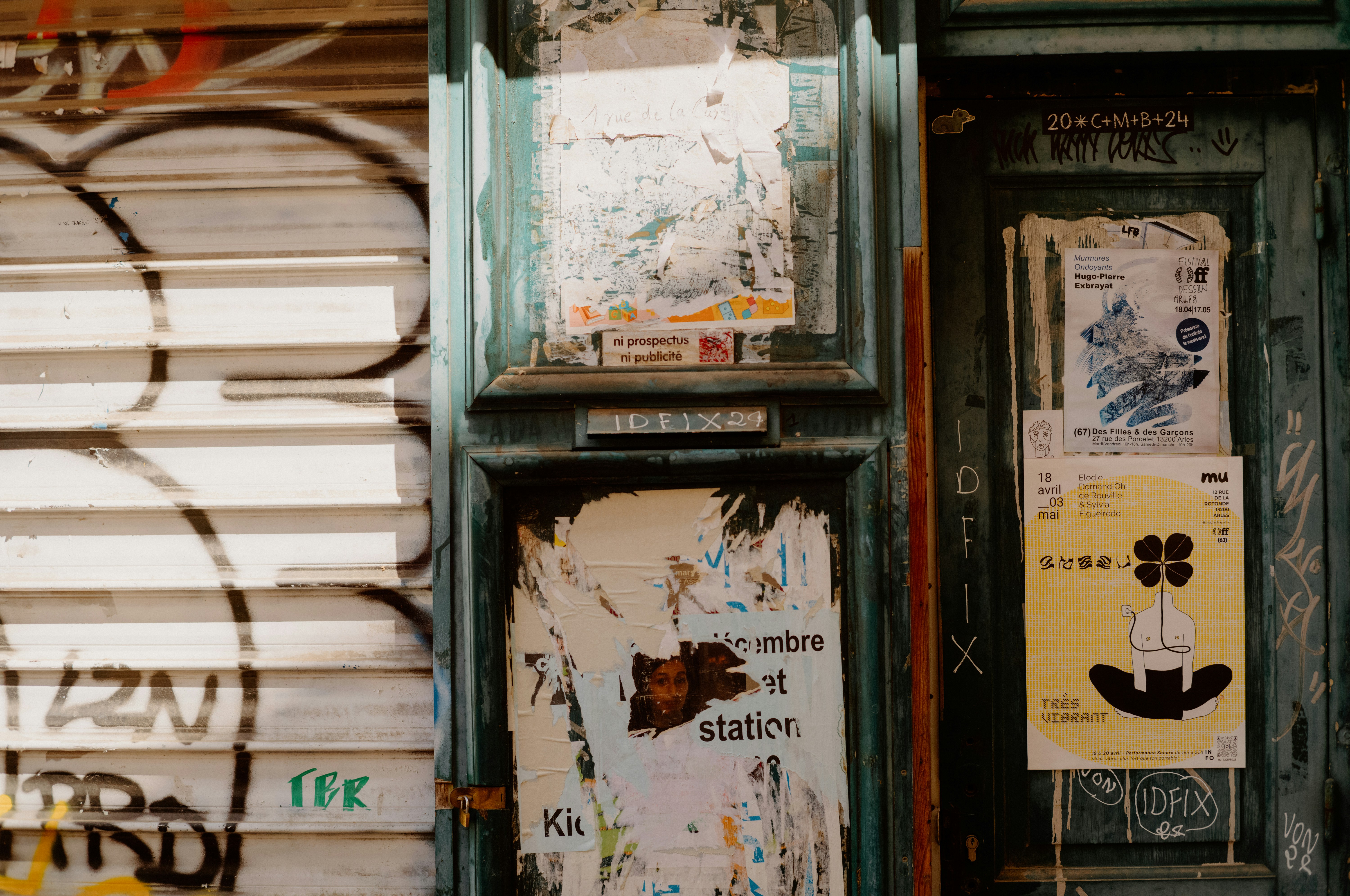 Weathered storefront marks and peeling posters in a grungy urban facade