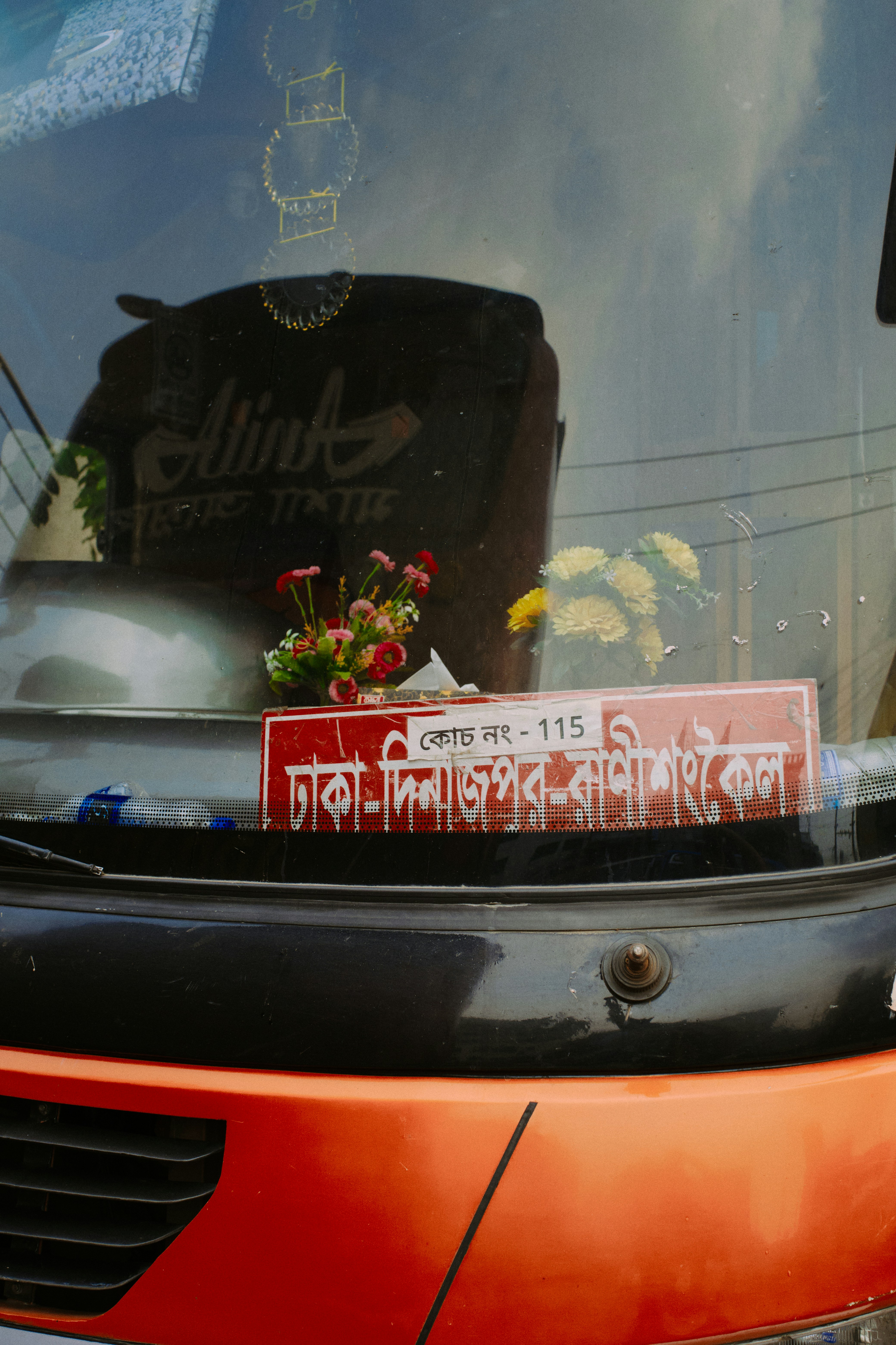 Crimson Dash: A Bus Windshield with Floral Keepsake