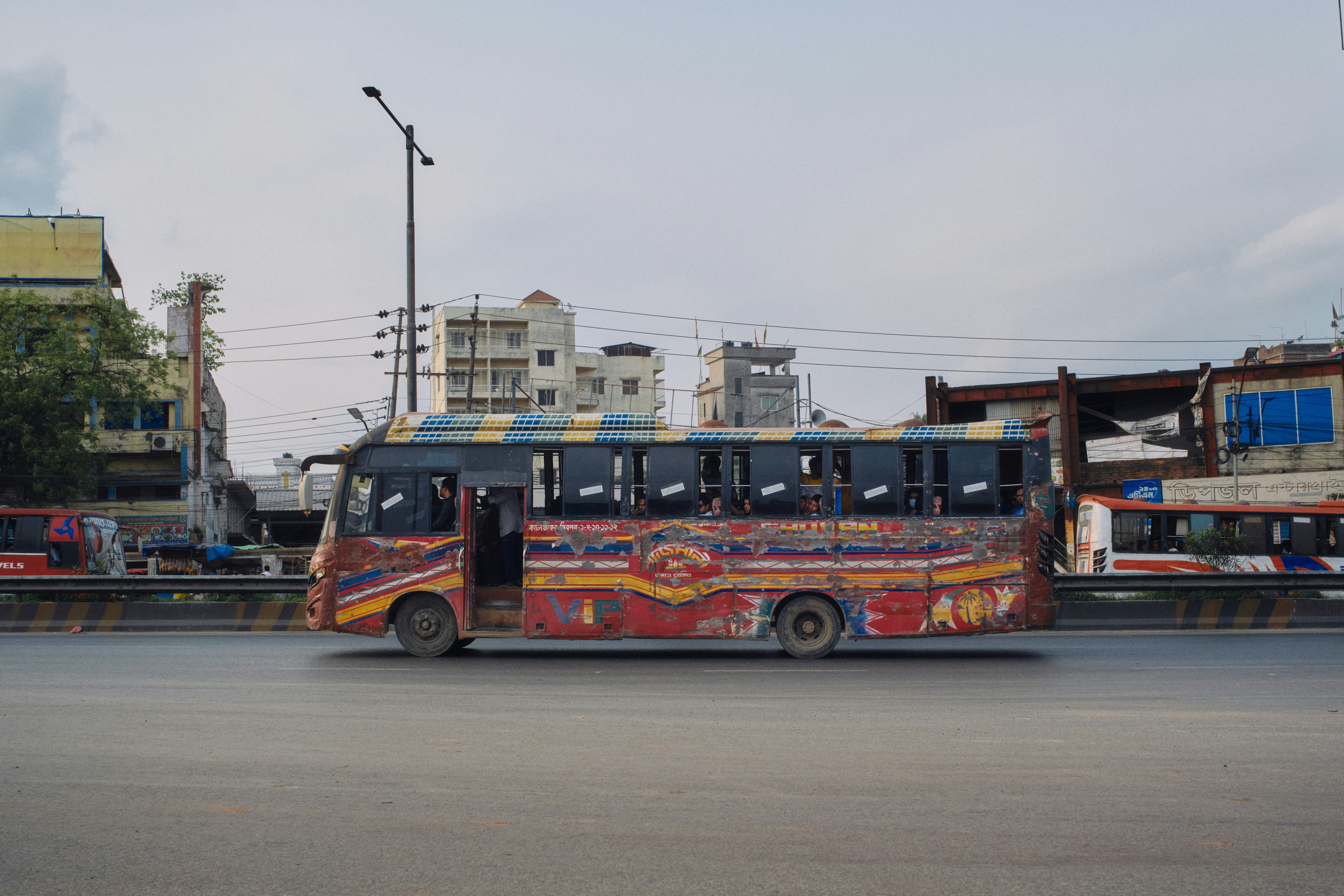 Colorful urban bus in motion along a weathered roadside