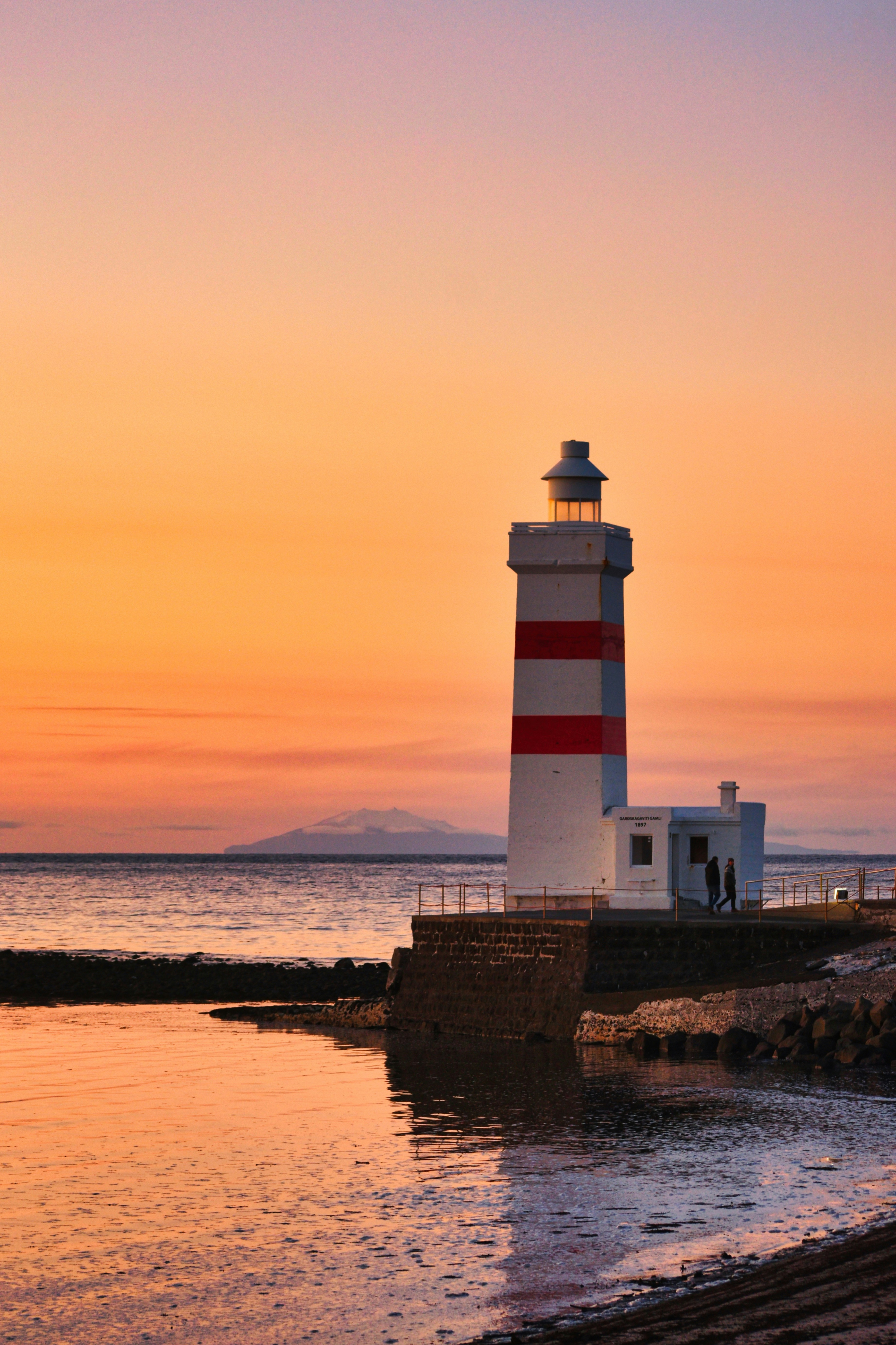 Sunset Beacon: The Striped Lighthouse at Quiet Dusk