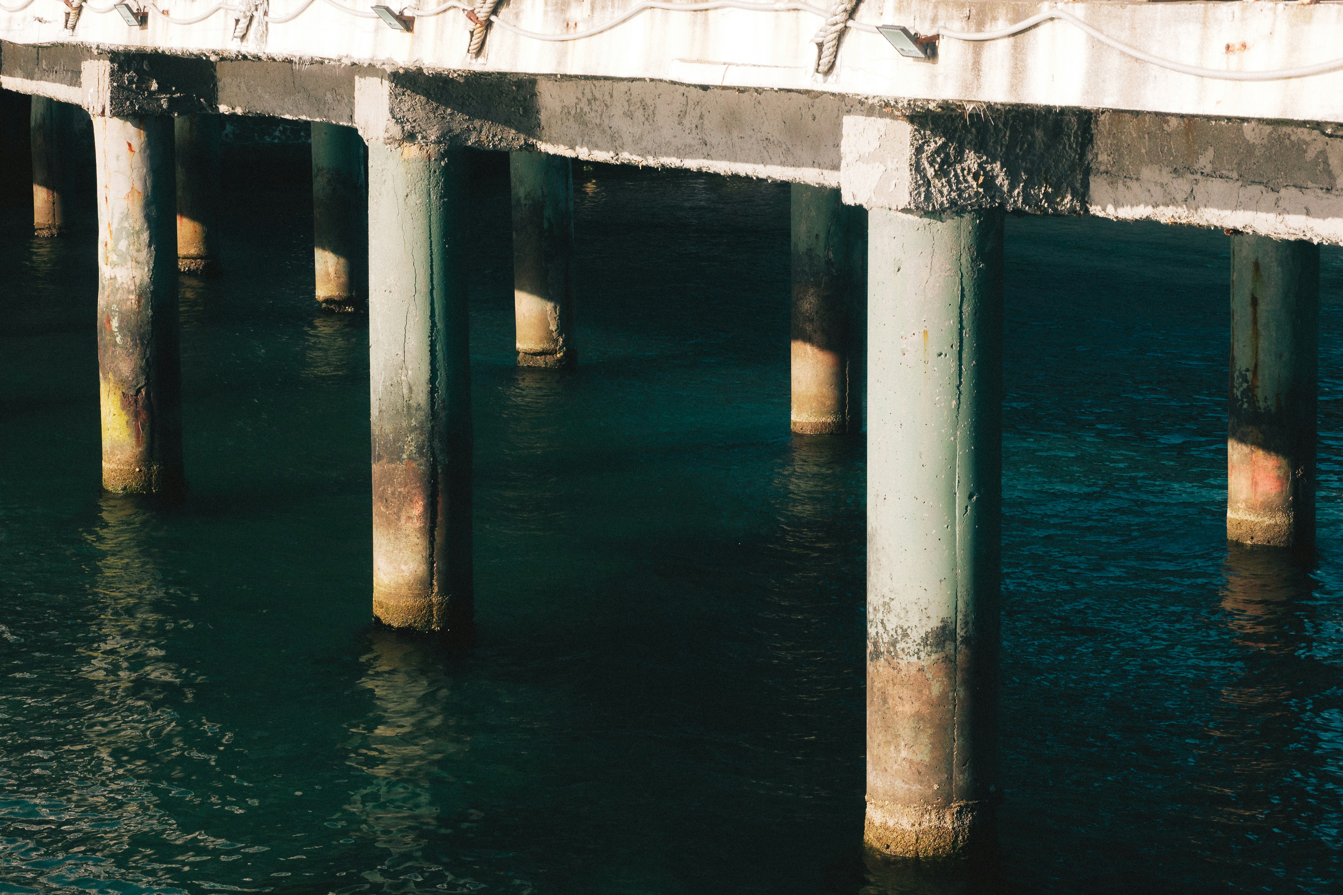 Columns of Calm: Sunlit Pilings Stretch Across Quiet Water