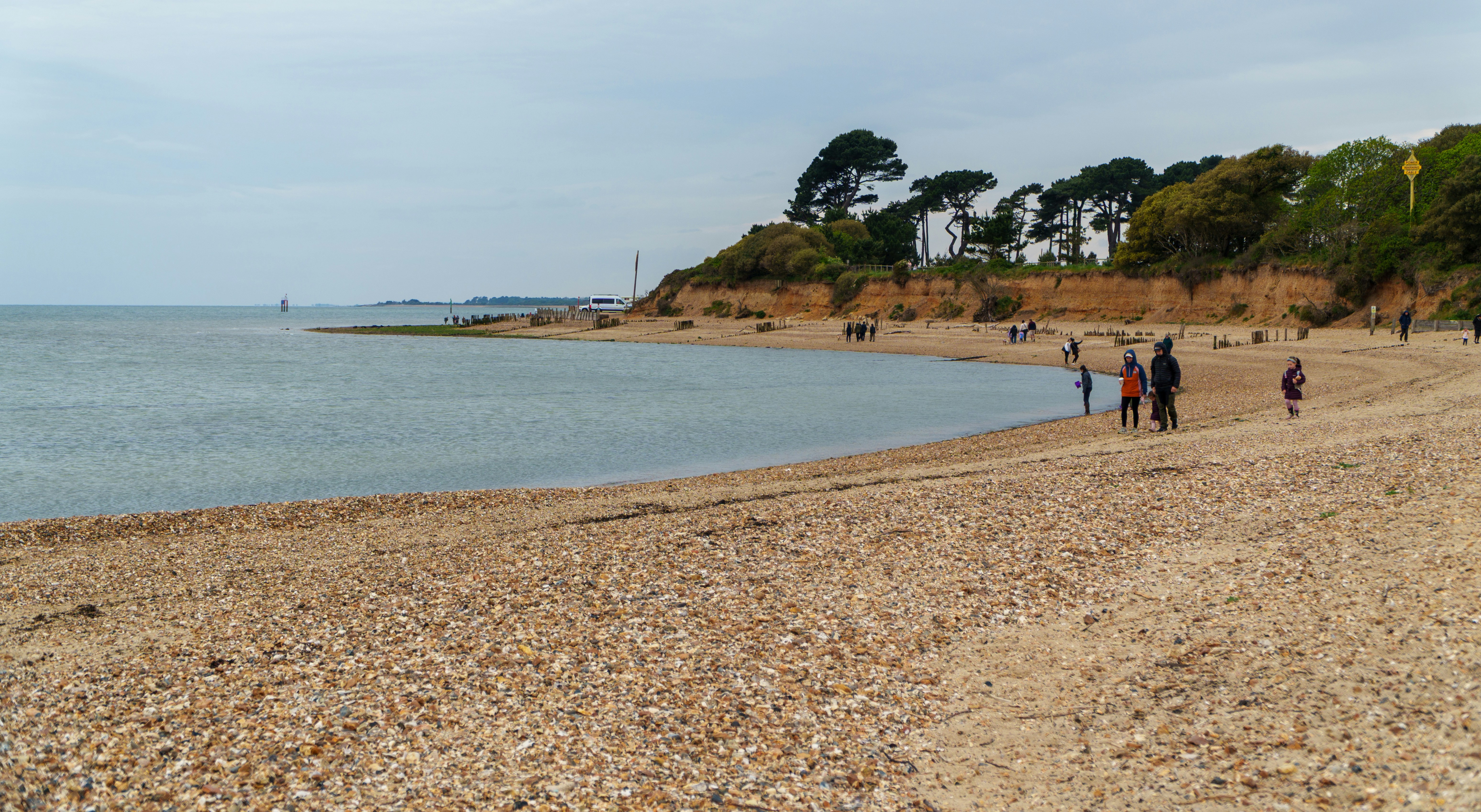 Coastal Pathway: People along a Pebble Beach Beneath Enterprising Clouds