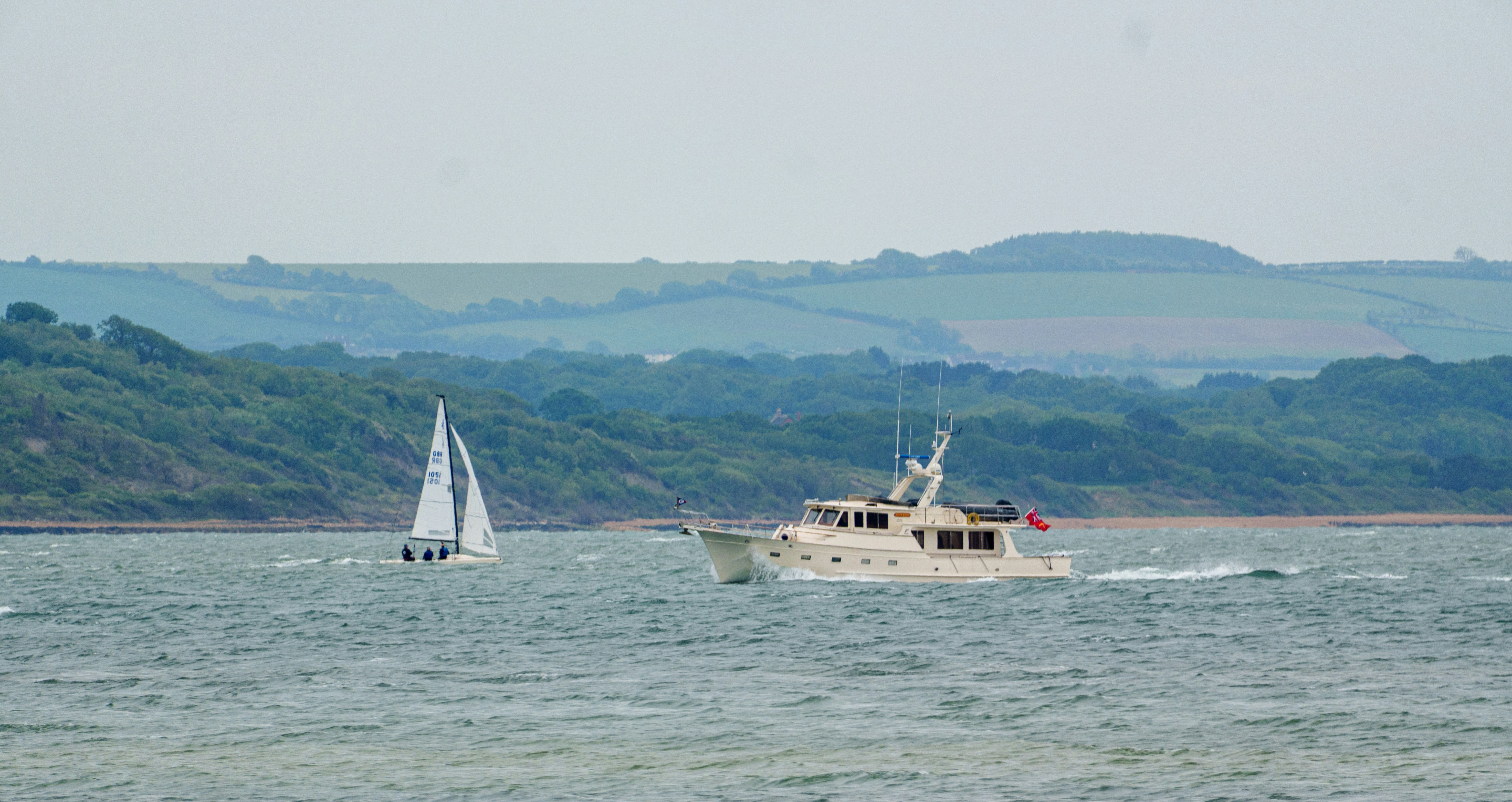Sailing and Motor Yacht Cut Through Coastal Calm