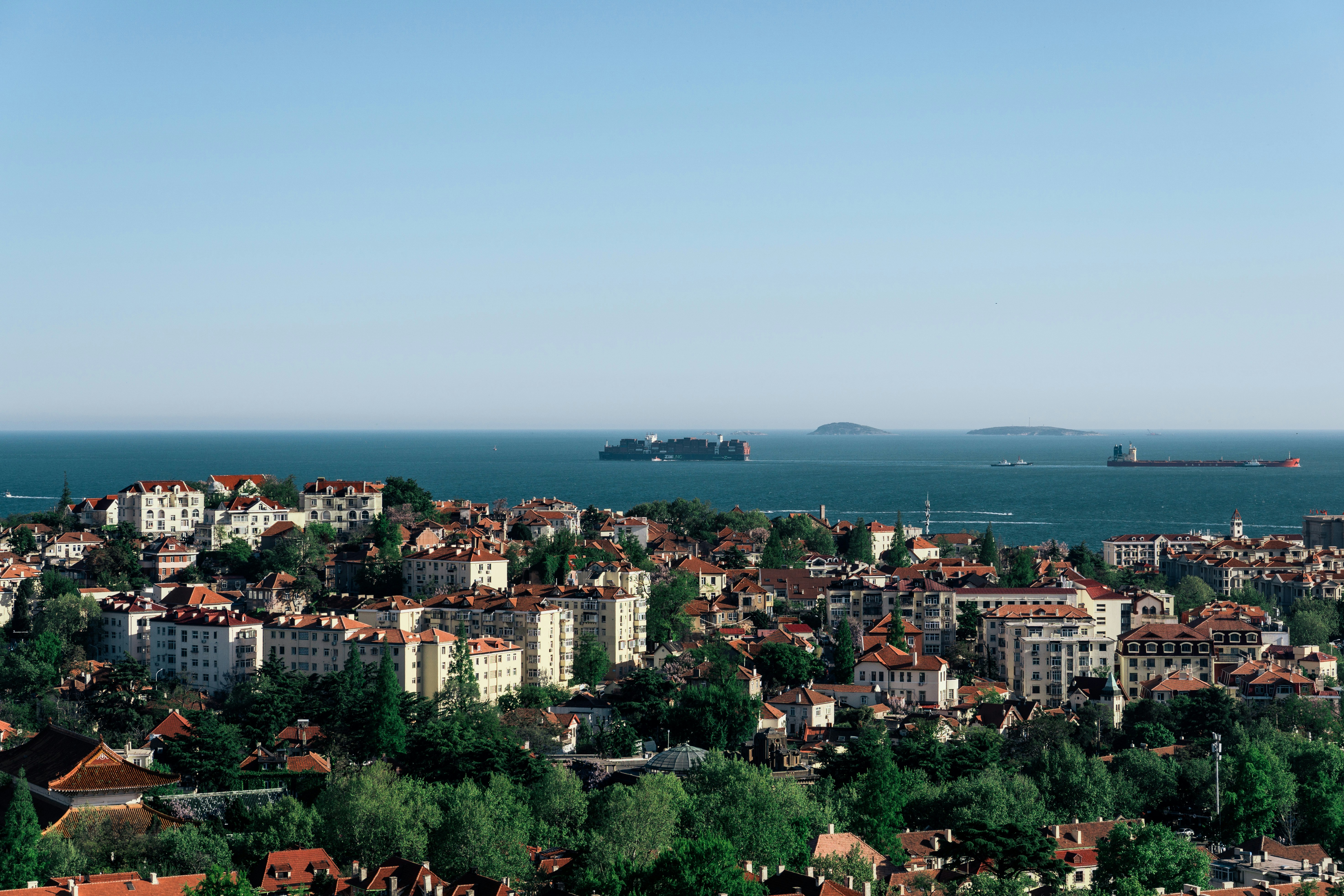 Coastal townscape: red-tiled rooftops meeting a calm blue horizon