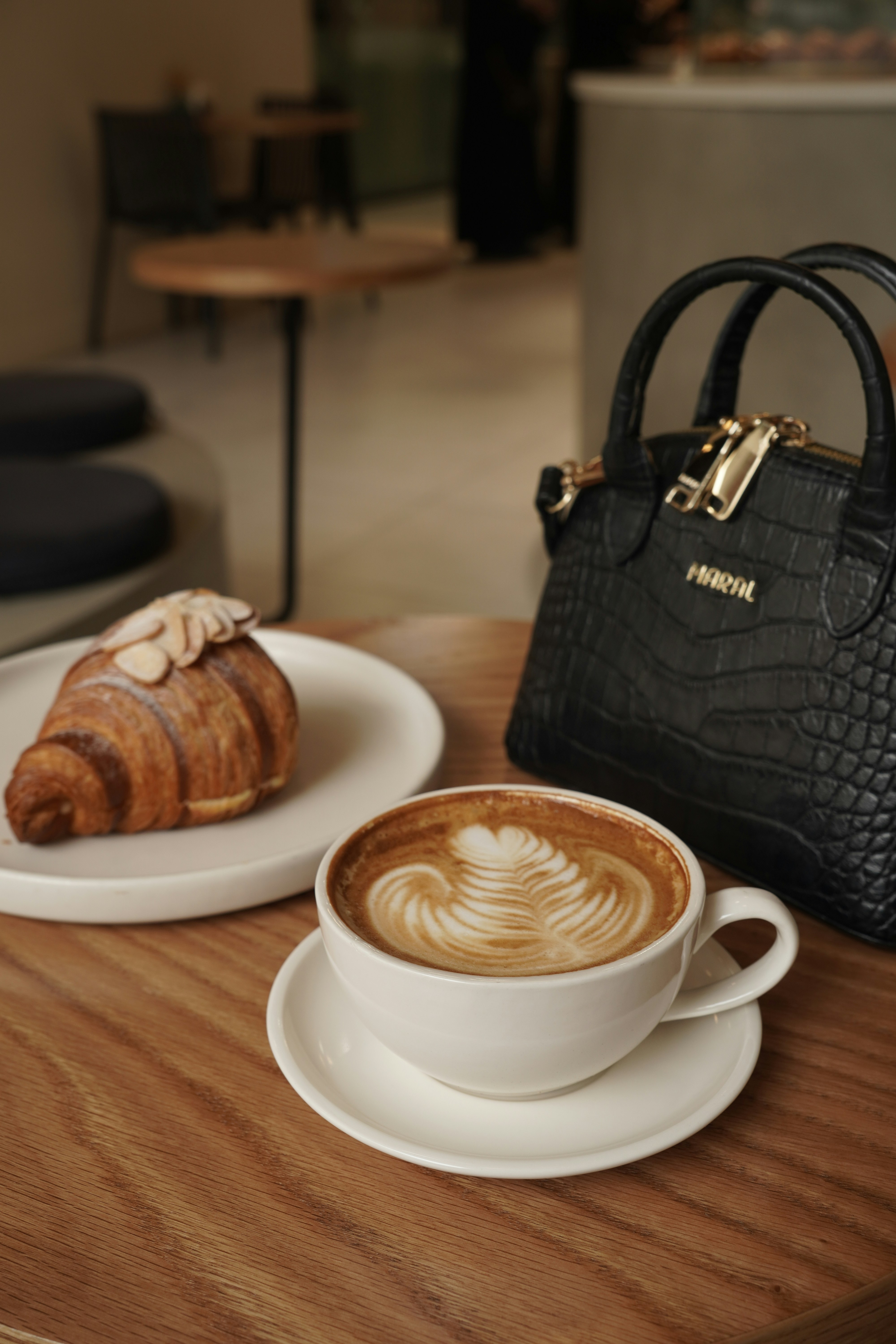 Cafe Latte Quietly Framing a Croissant and Handbag Moment