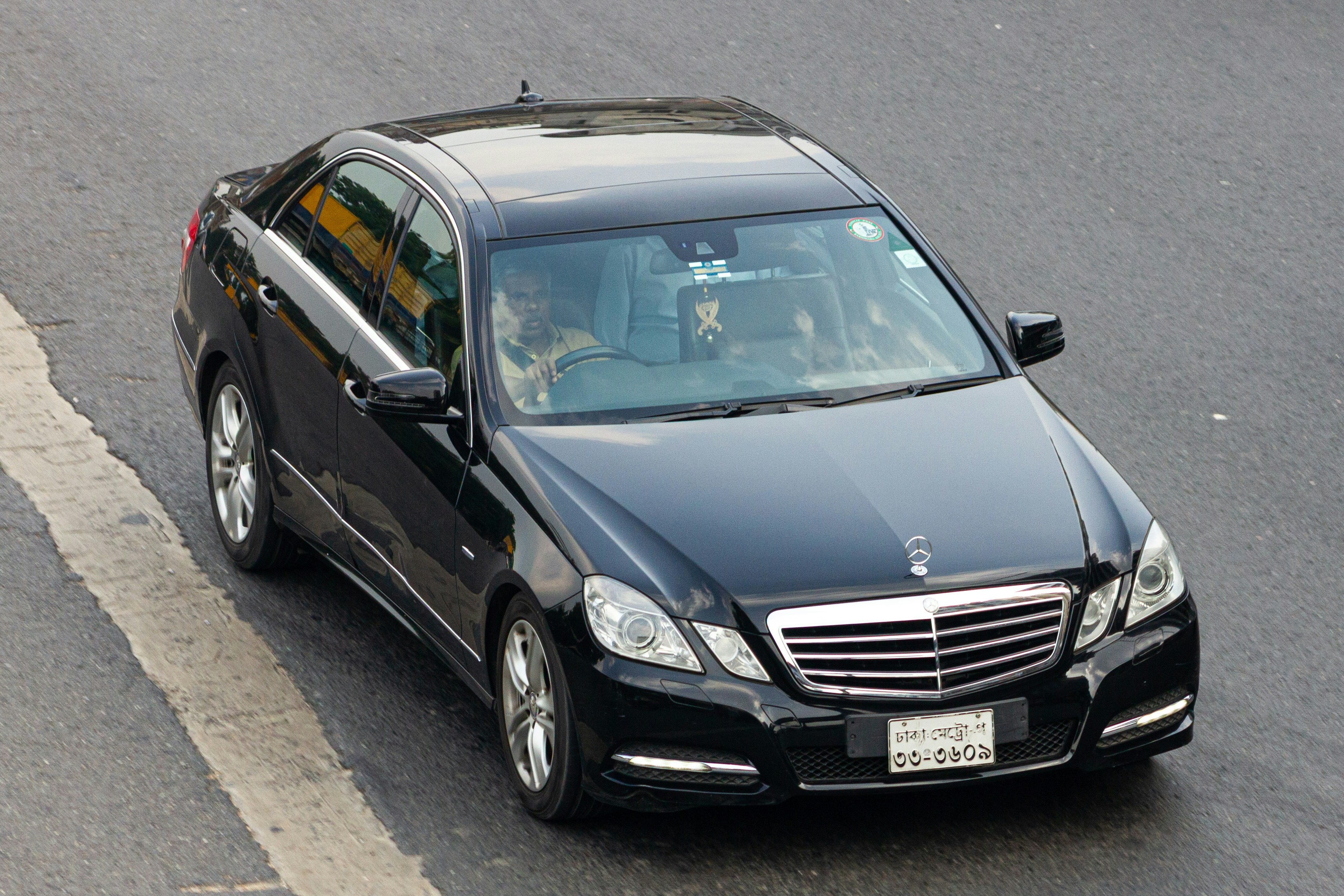 Black luxury sedan captured from a slight aerial angle with chrome accents catching light