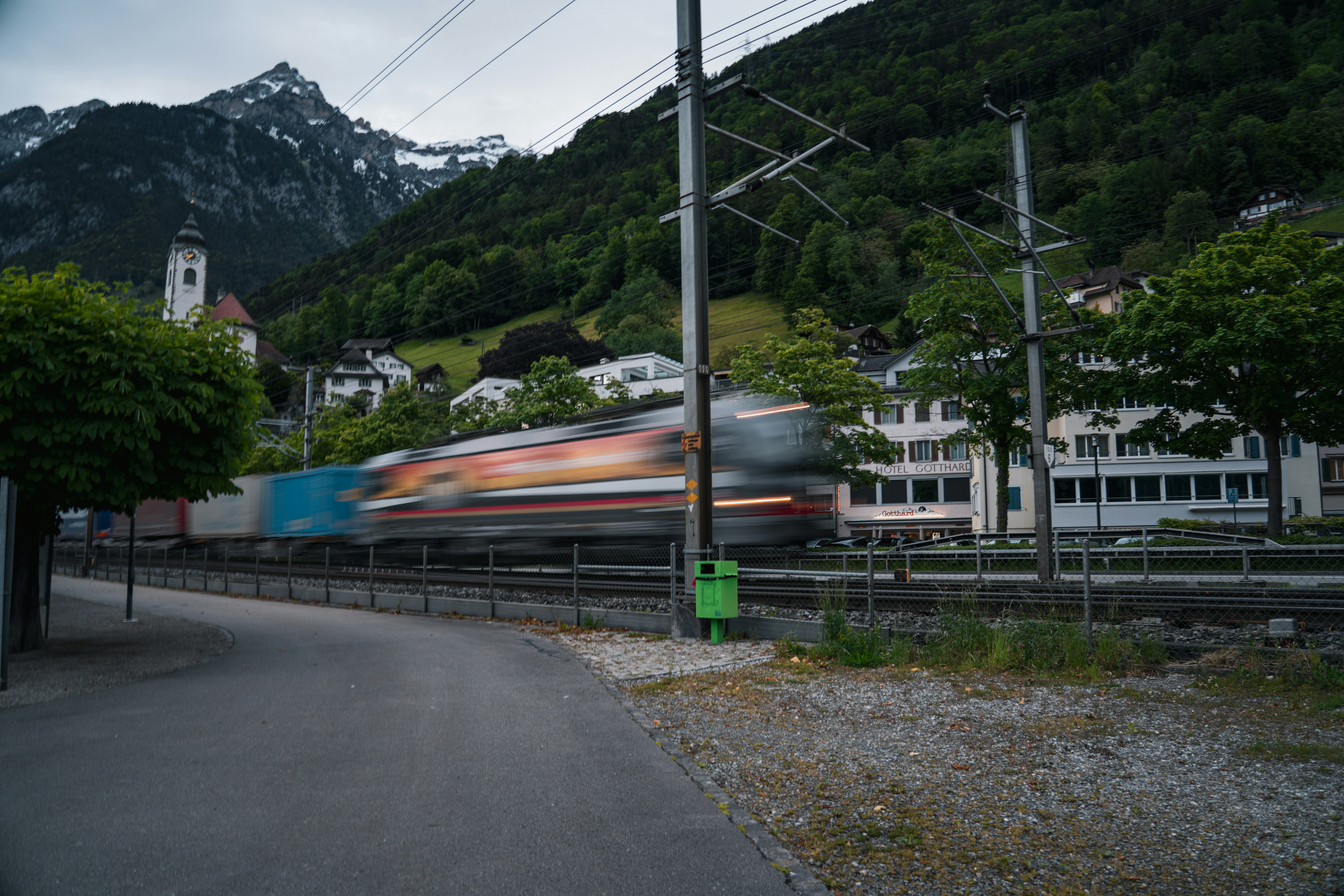 Blurred Freight Train Through Alpine Town