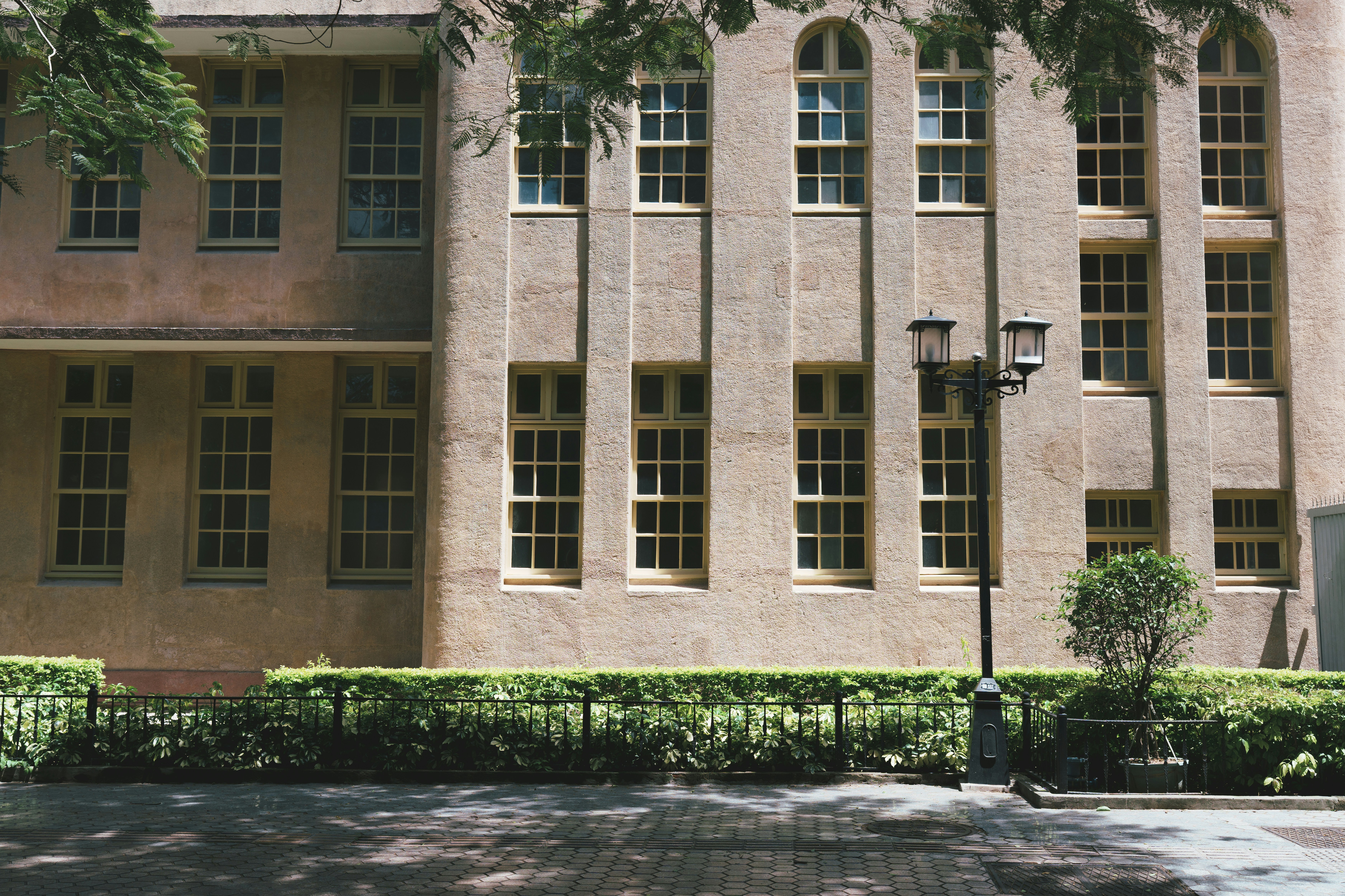 A building with many windows and green bushes photo – Free Architecture ...