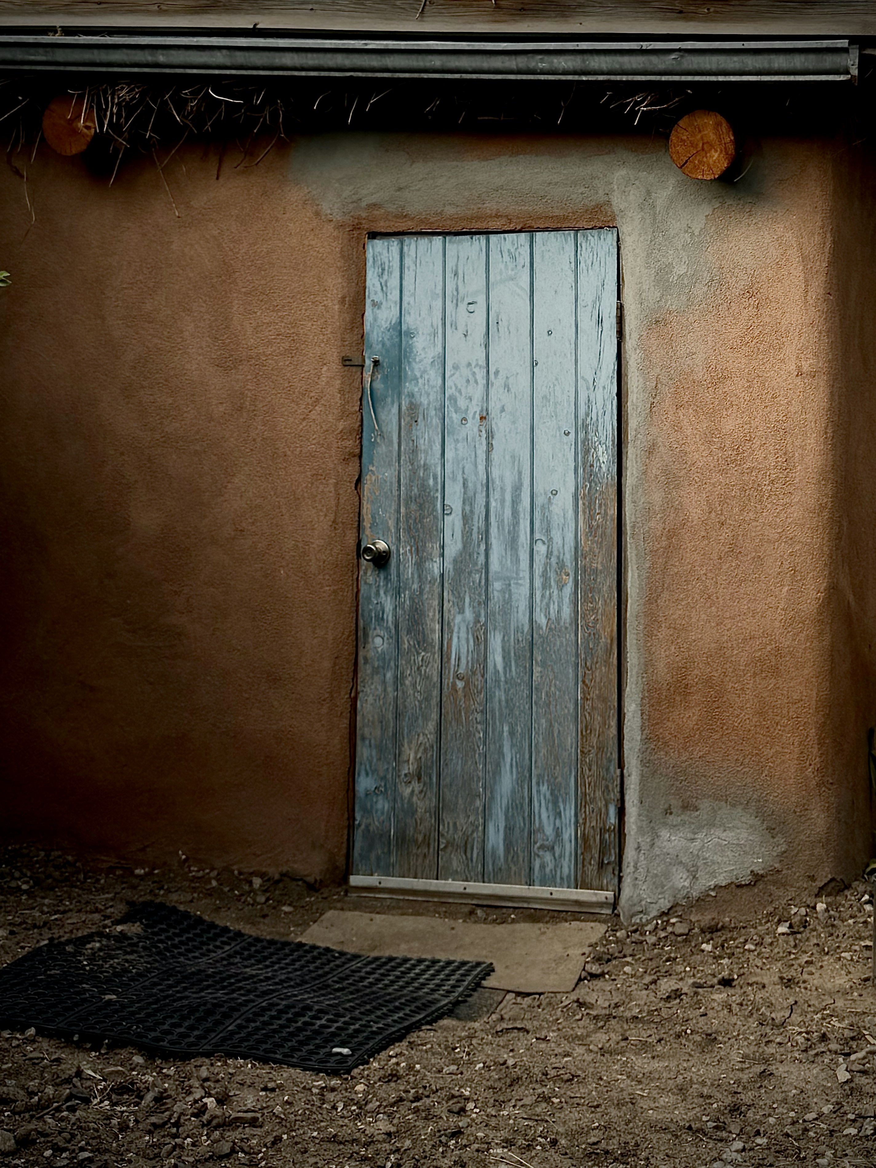 Weathered Blue Door in Earthen Wall