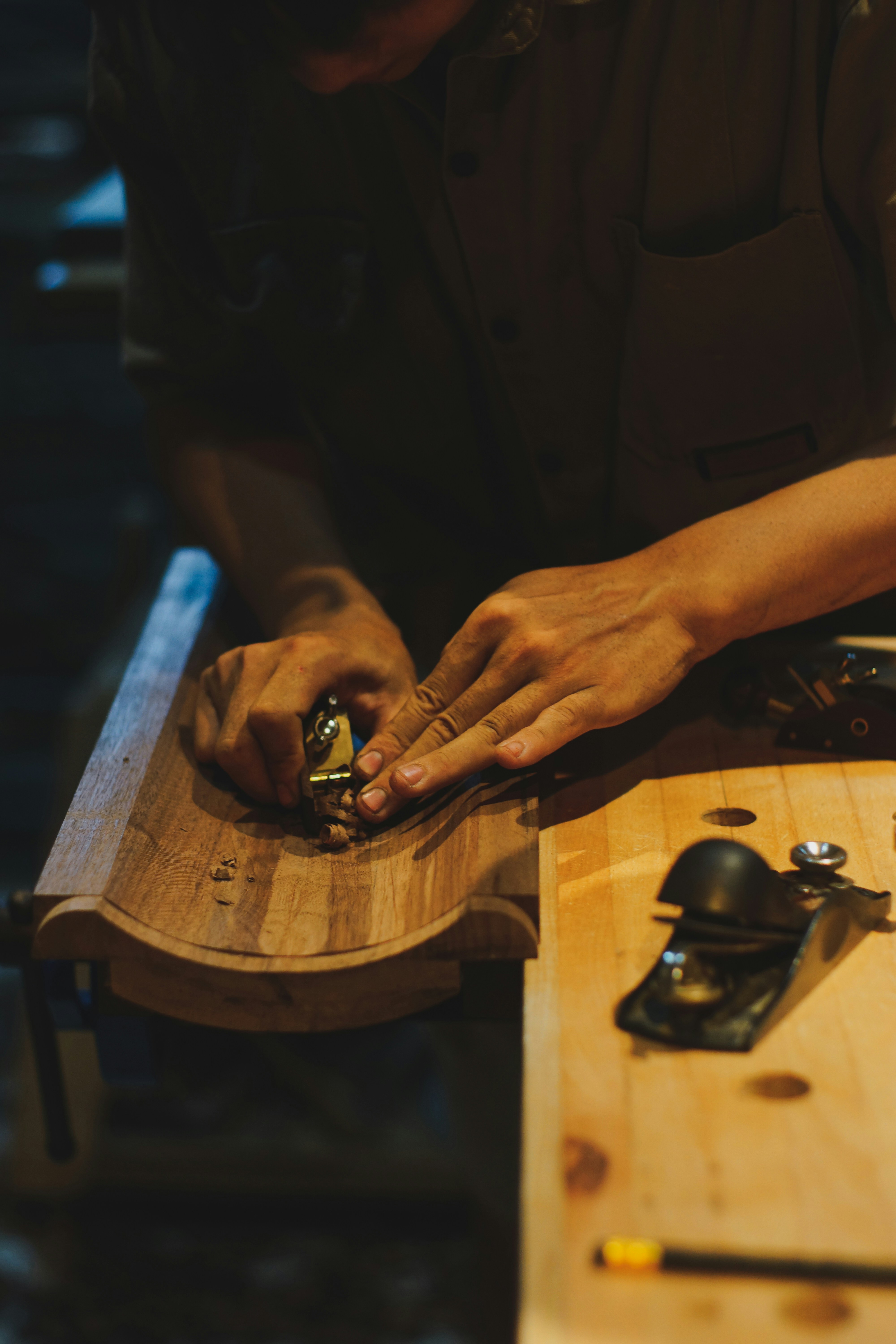 Wooden Shavings and Hands: Crafting Details in a Carpenter's Workspace