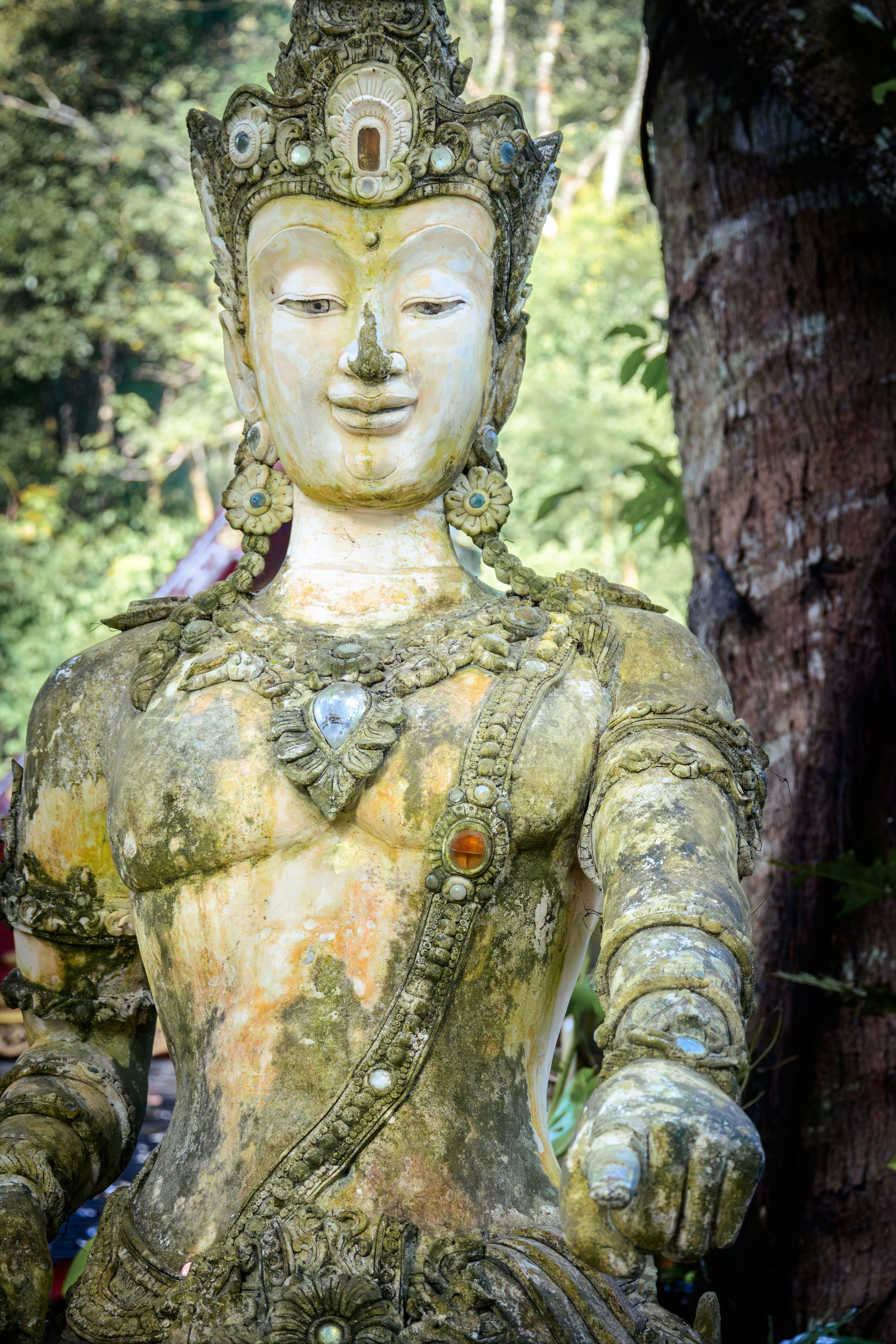Stone Guardian: serene statue under forest canopy