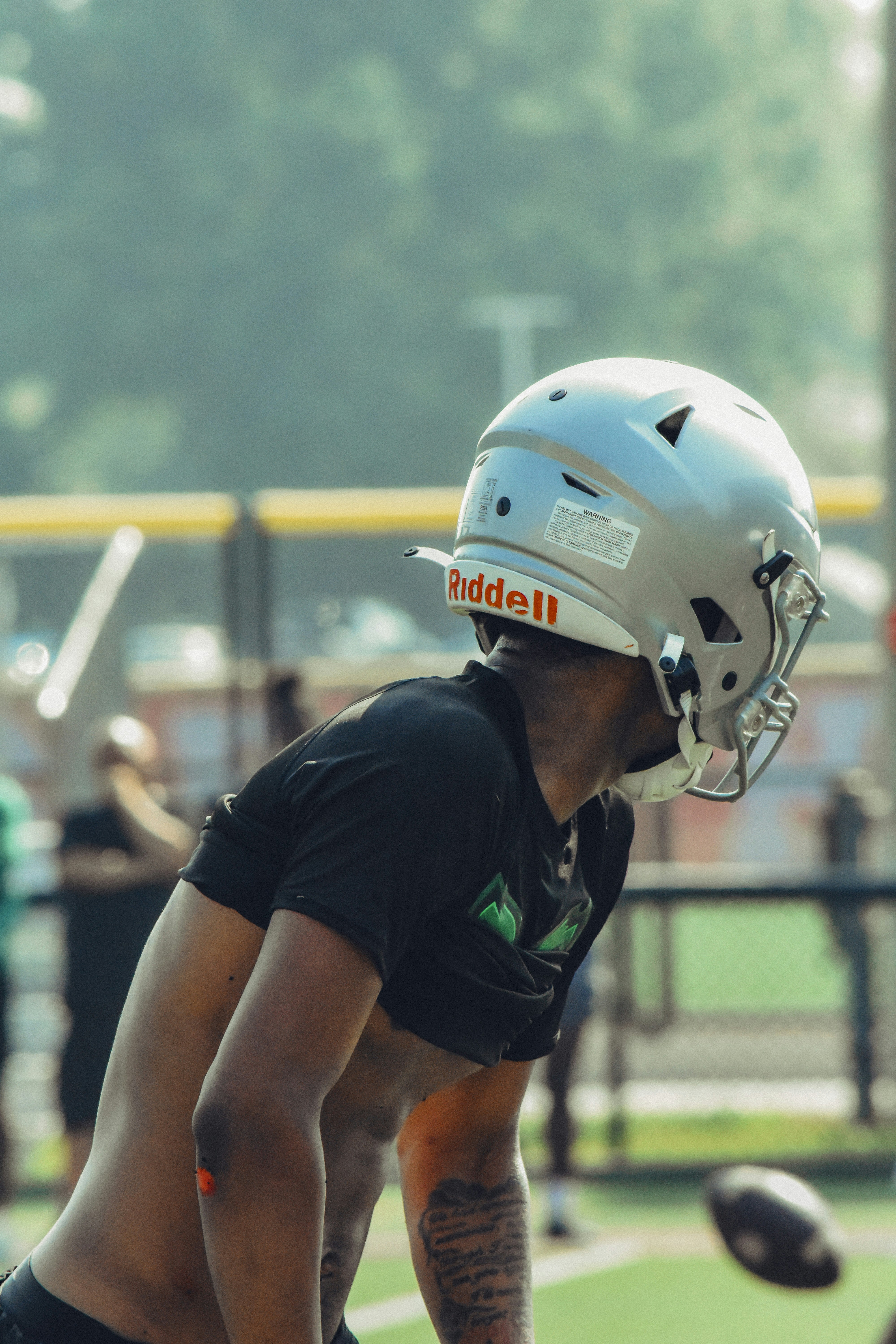 Helmeted Athlete in Motion: Side-Facing Portrait on a Sunny Field