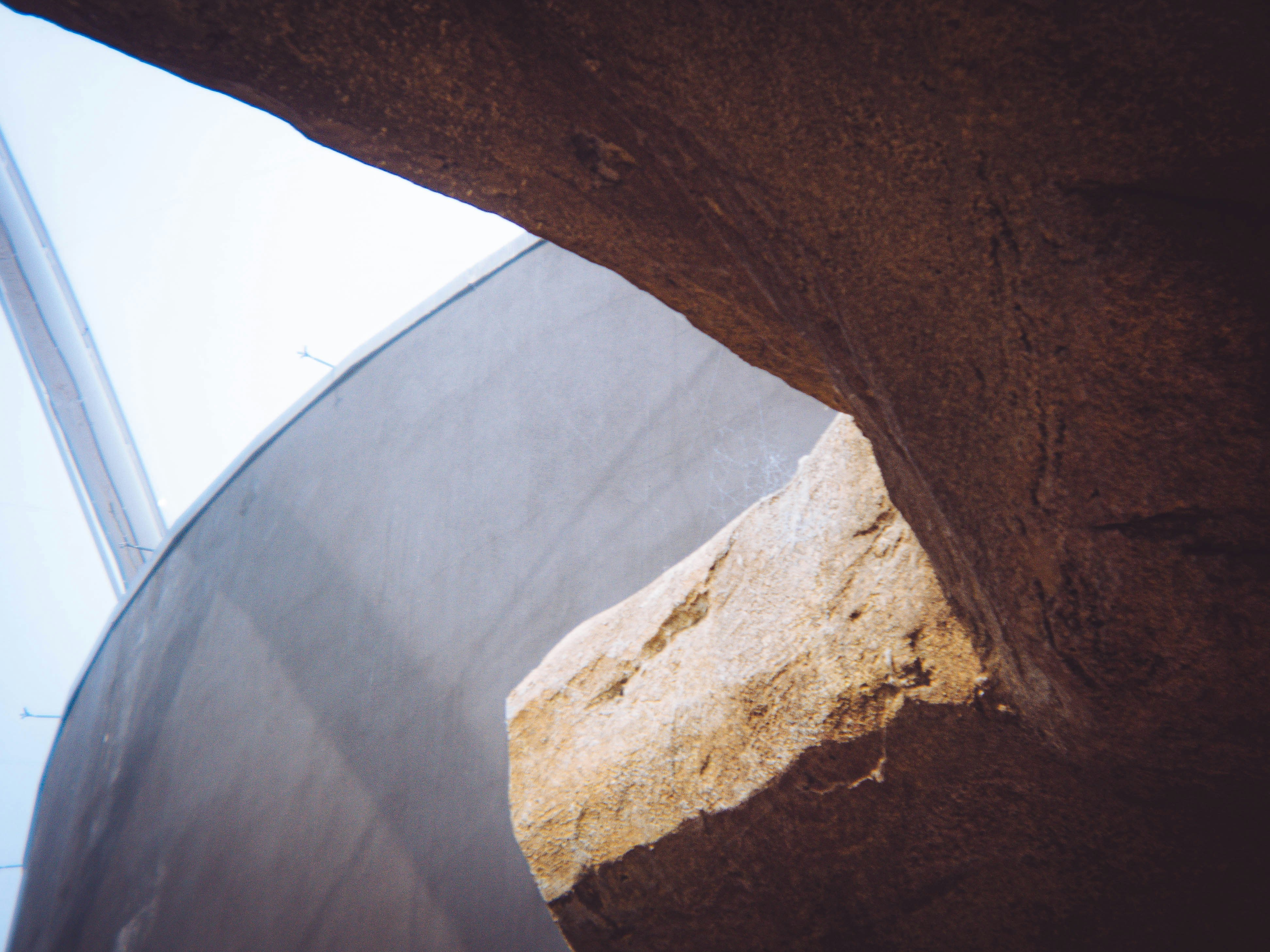 Curved Concrete Breeze: An Archway Framing a Cliff of Light