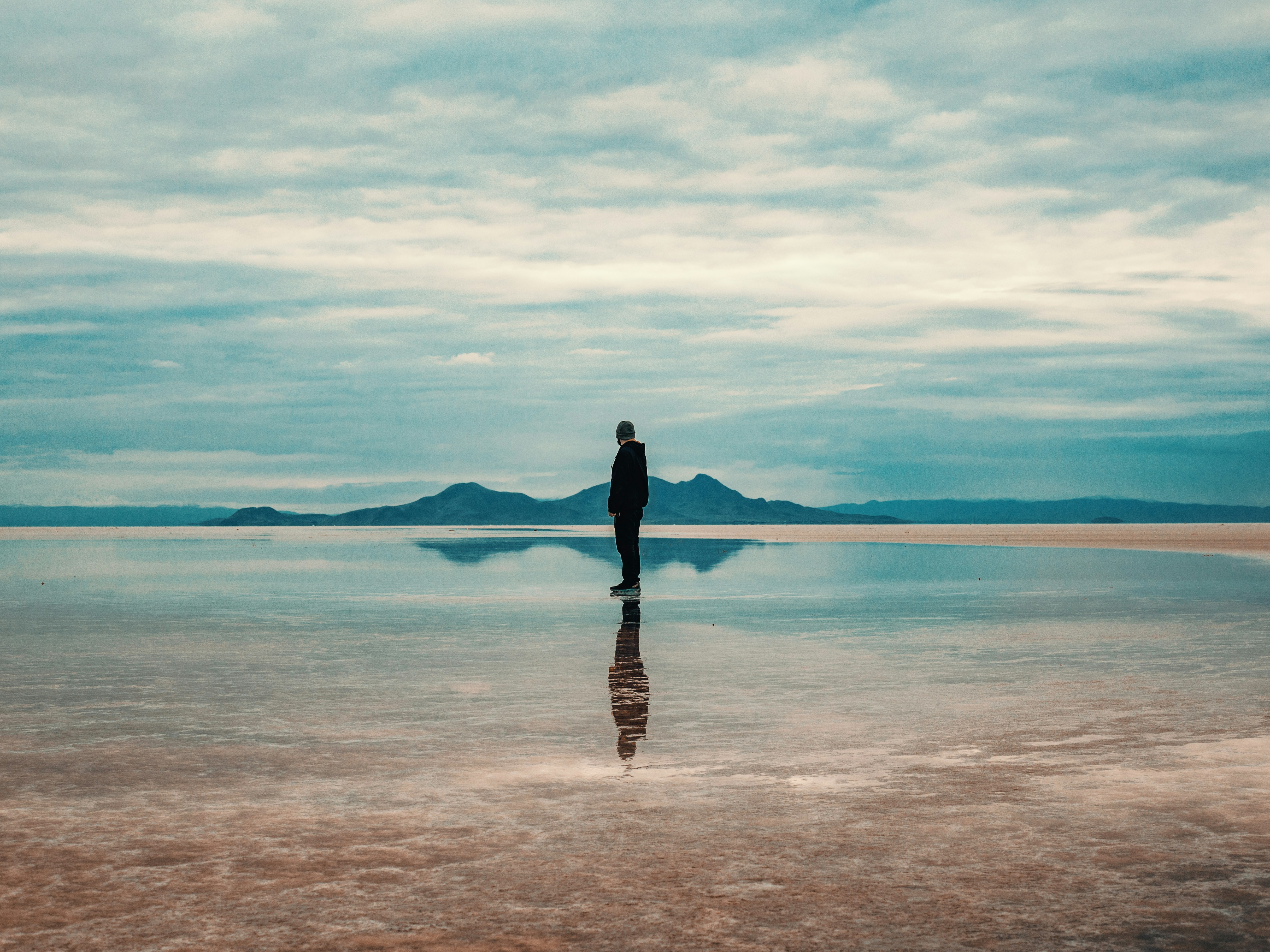  solitary wanderer on mirrored salt flats at dusk
