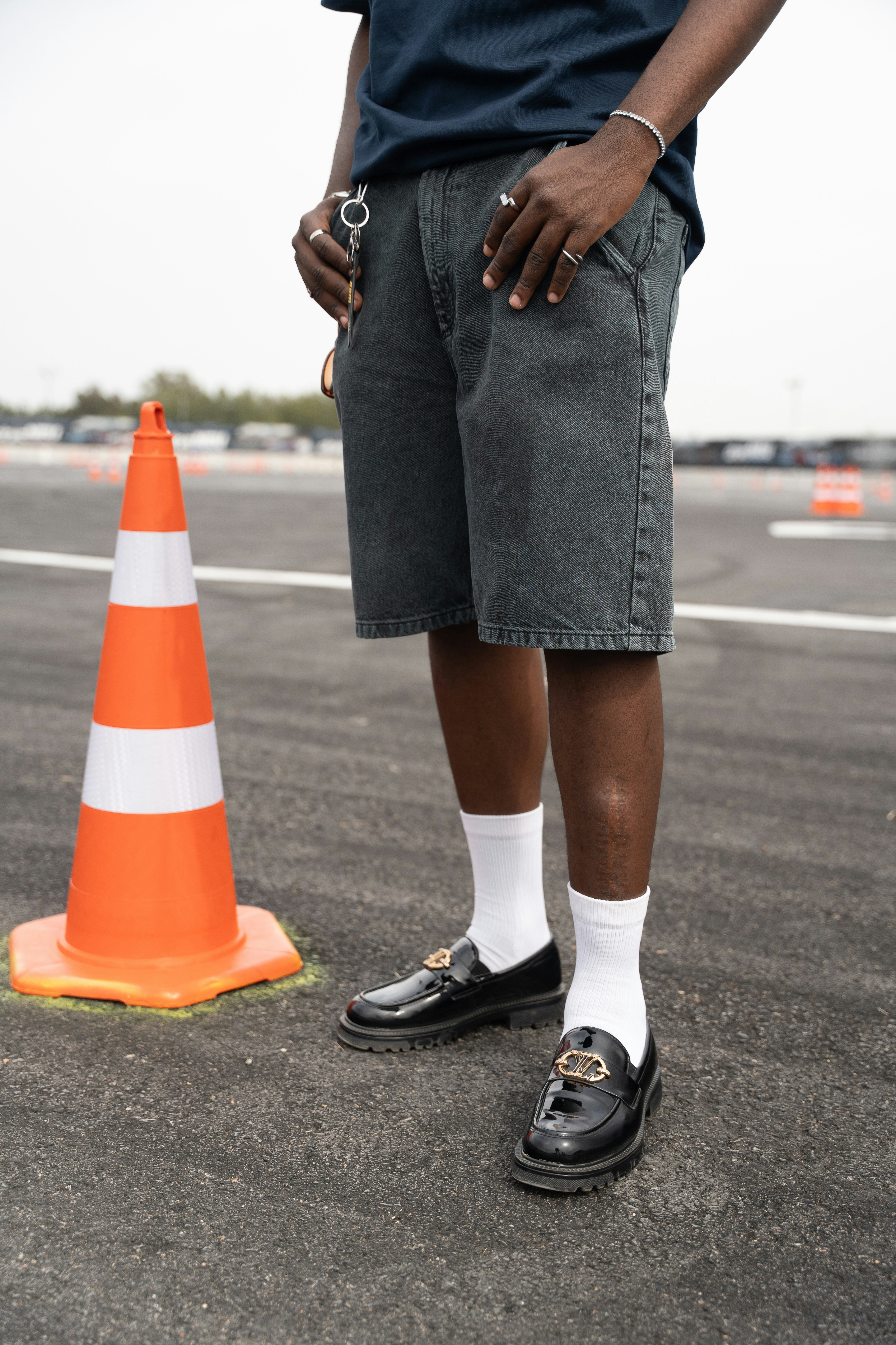 Front-View Detail: Streetwear Hem and Accessories at a Parking Lot