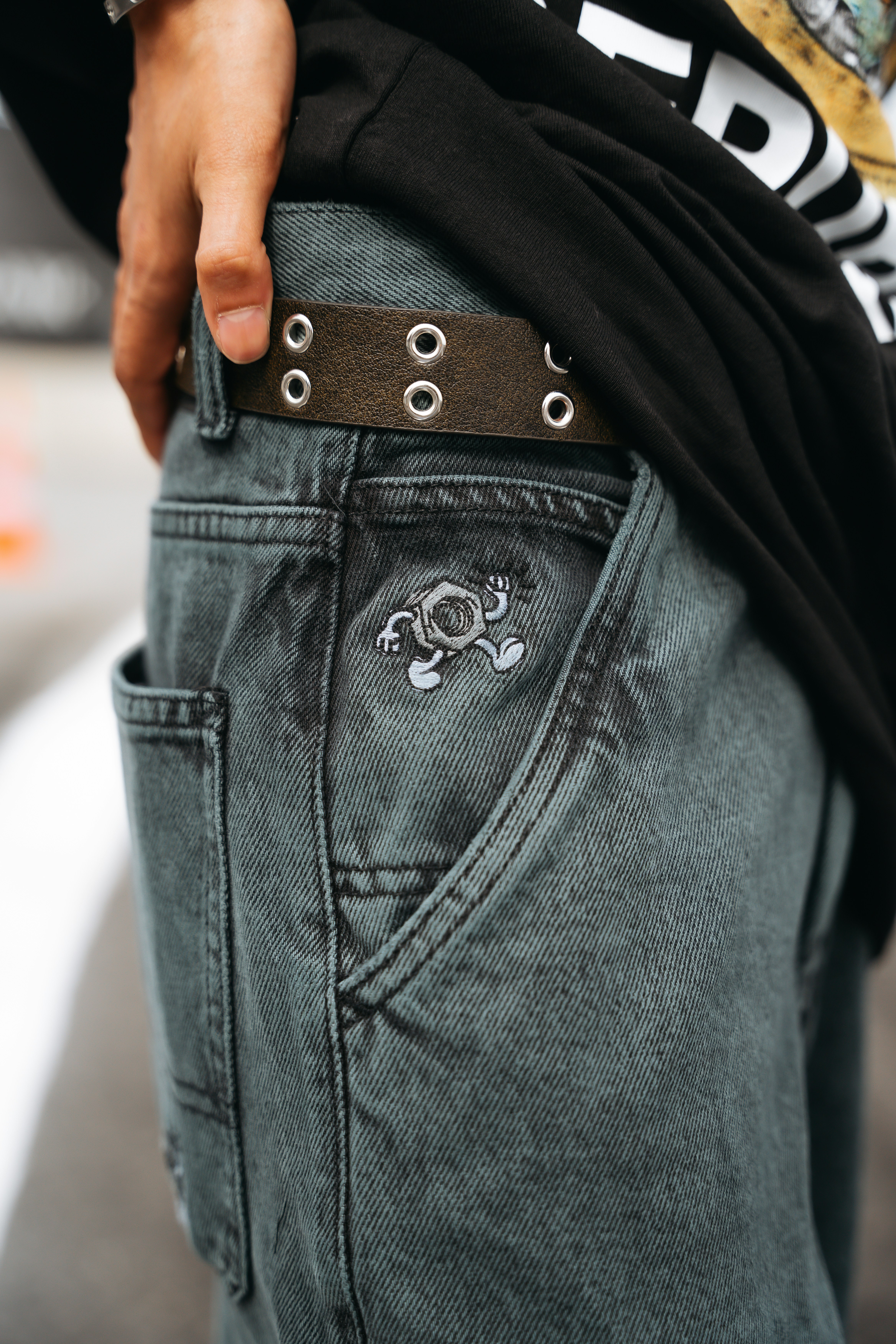  denim detail: a pocket, a patch and a studded belt