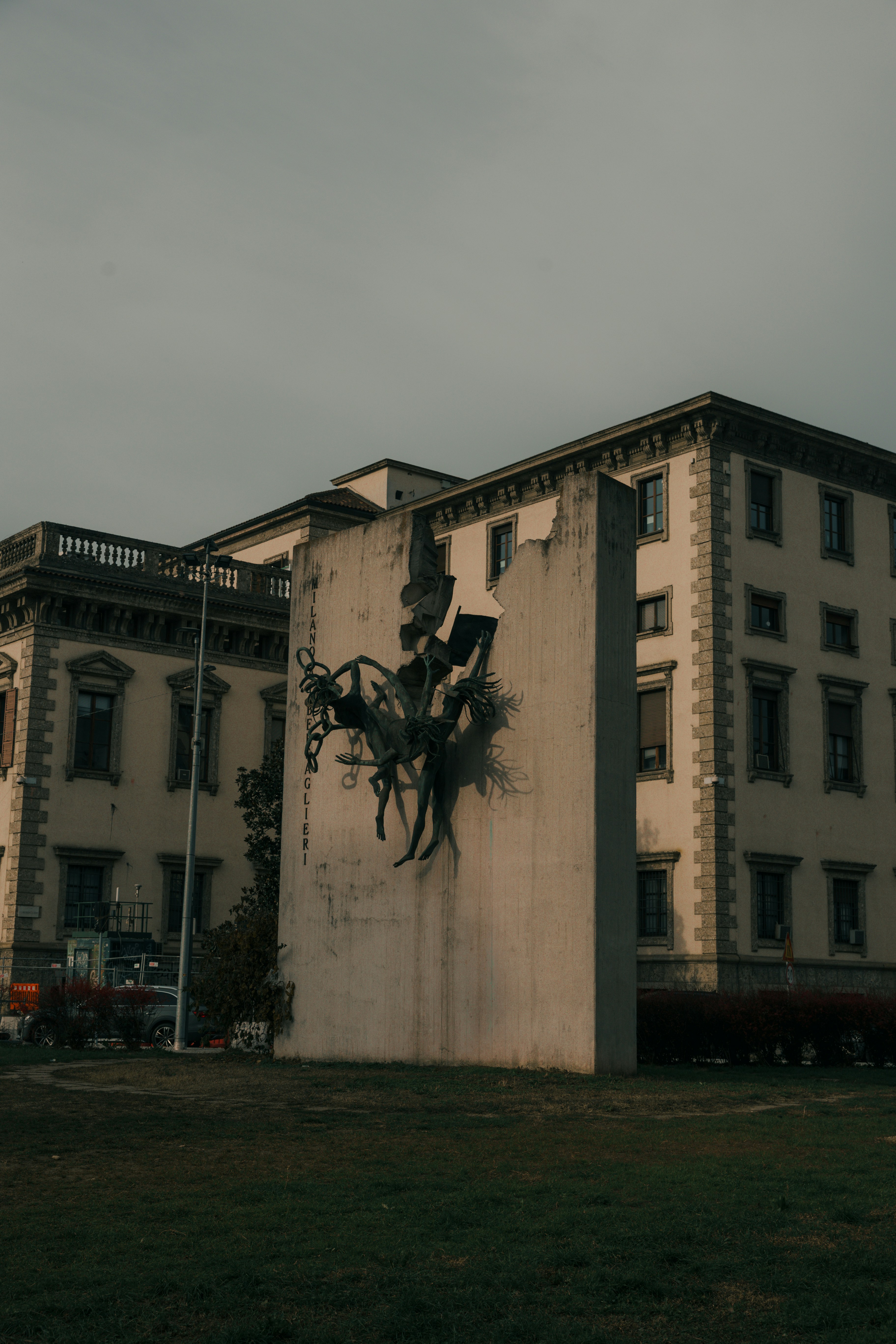 Monumental Shadow: A public sculpture in front of a weathered institutional facade