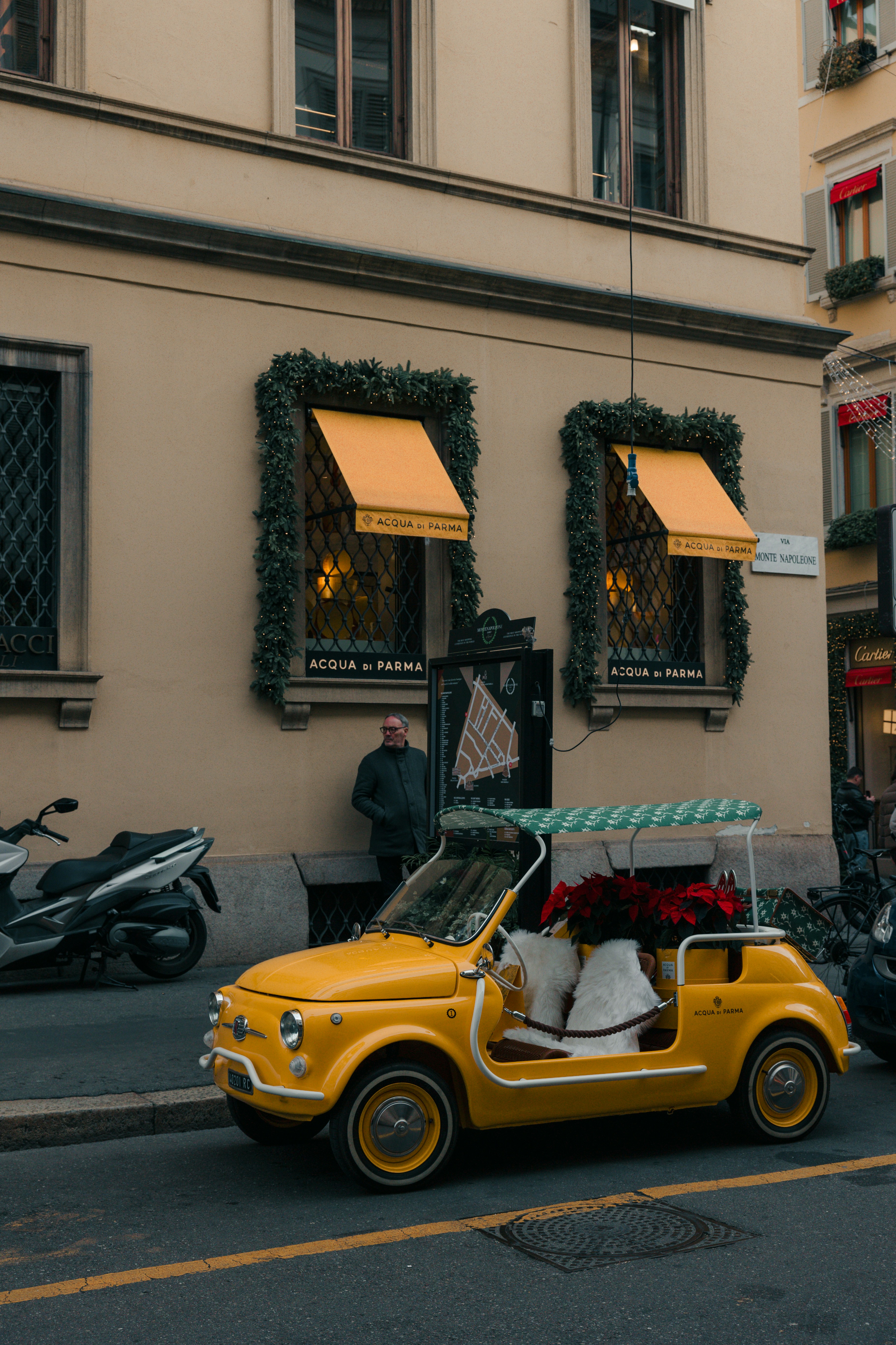 Yellow Vintage Taxi with Green Canopy Ribbons in Front of an Elegant storefront