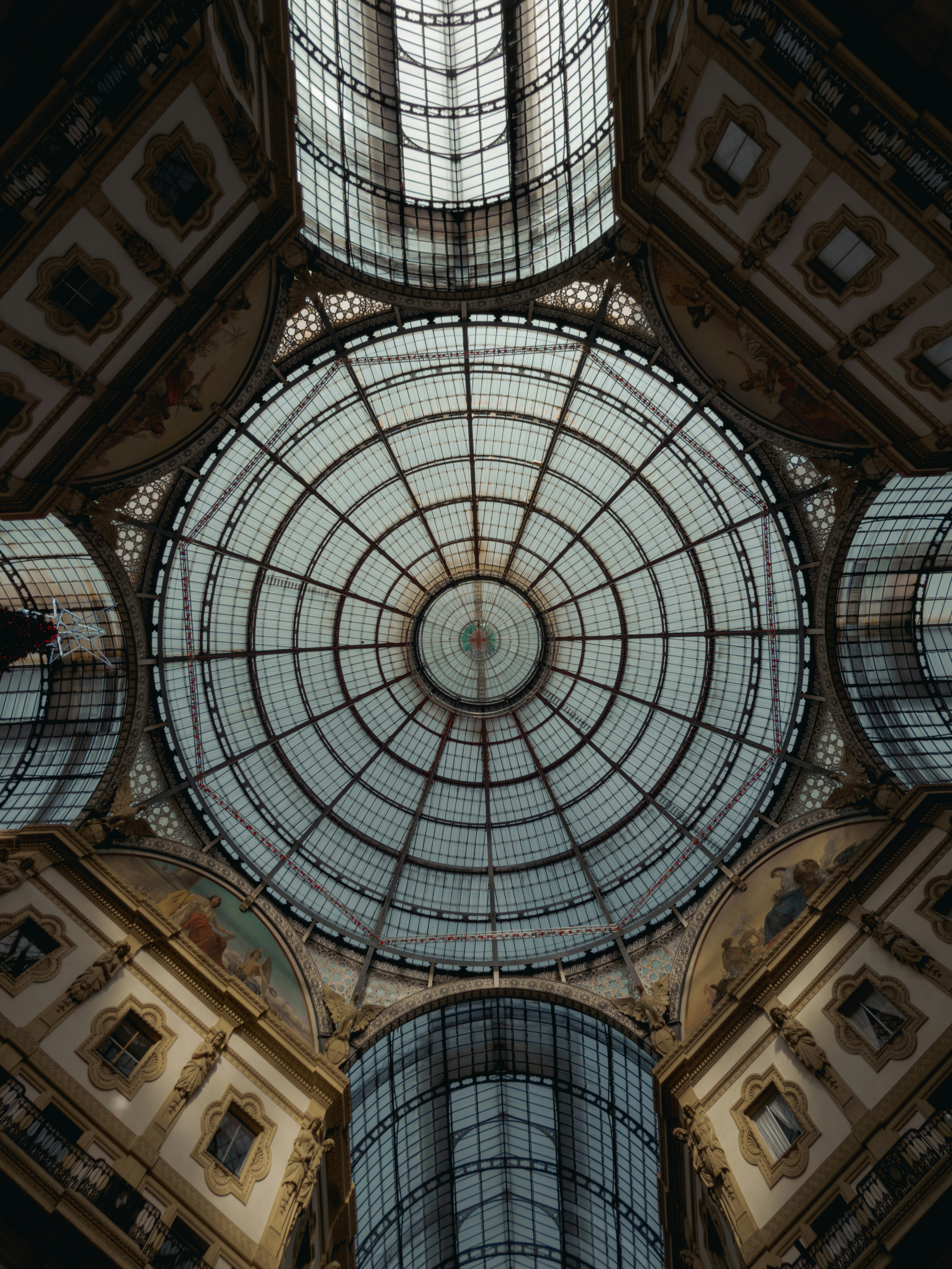 Intricate glass dome ceiling and ornate architectural details.