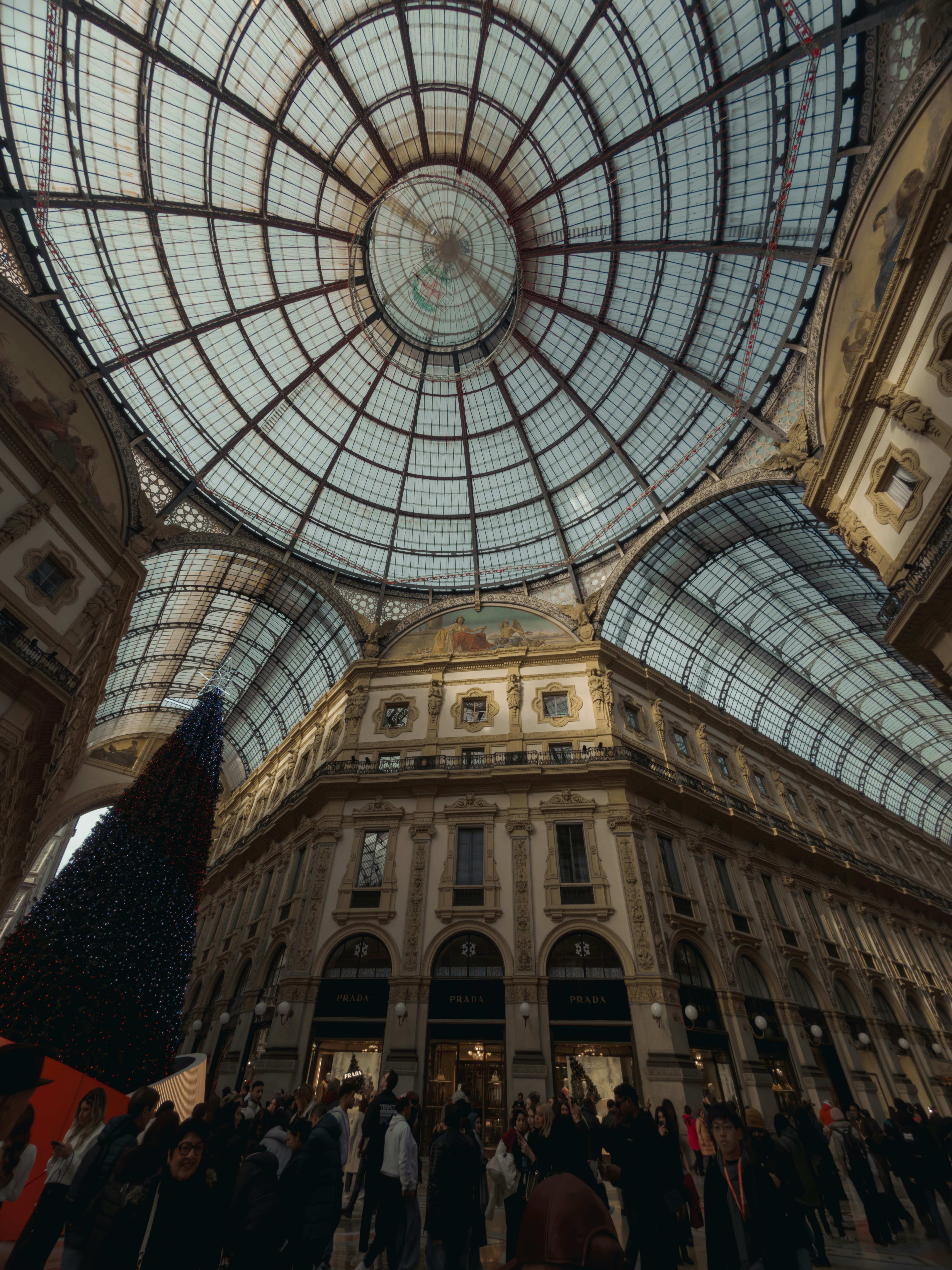 Grand glass dome ceiling over a busy shopping arcade.