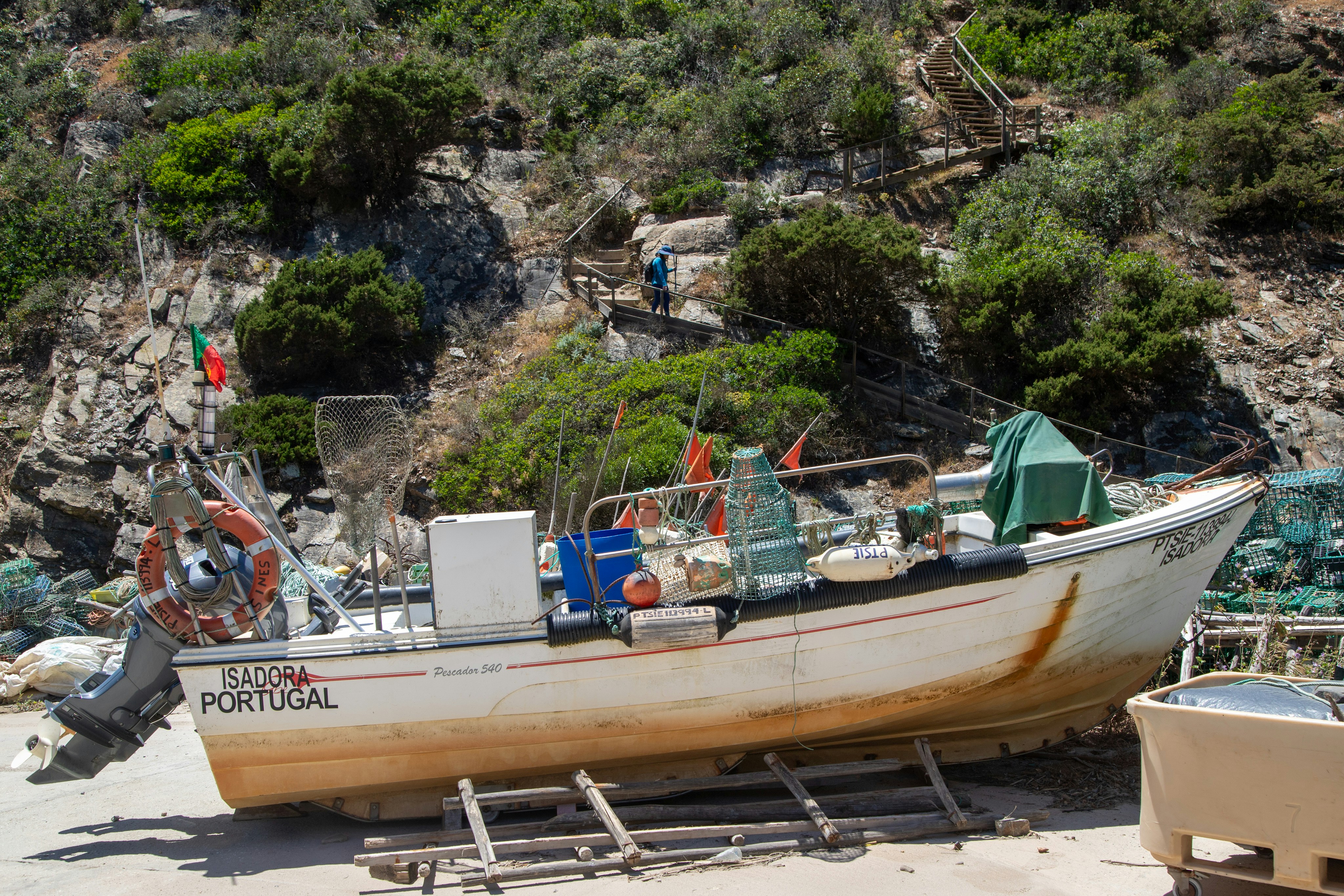 Marina relic: a weathered fishing boat resting on the sunlit shore