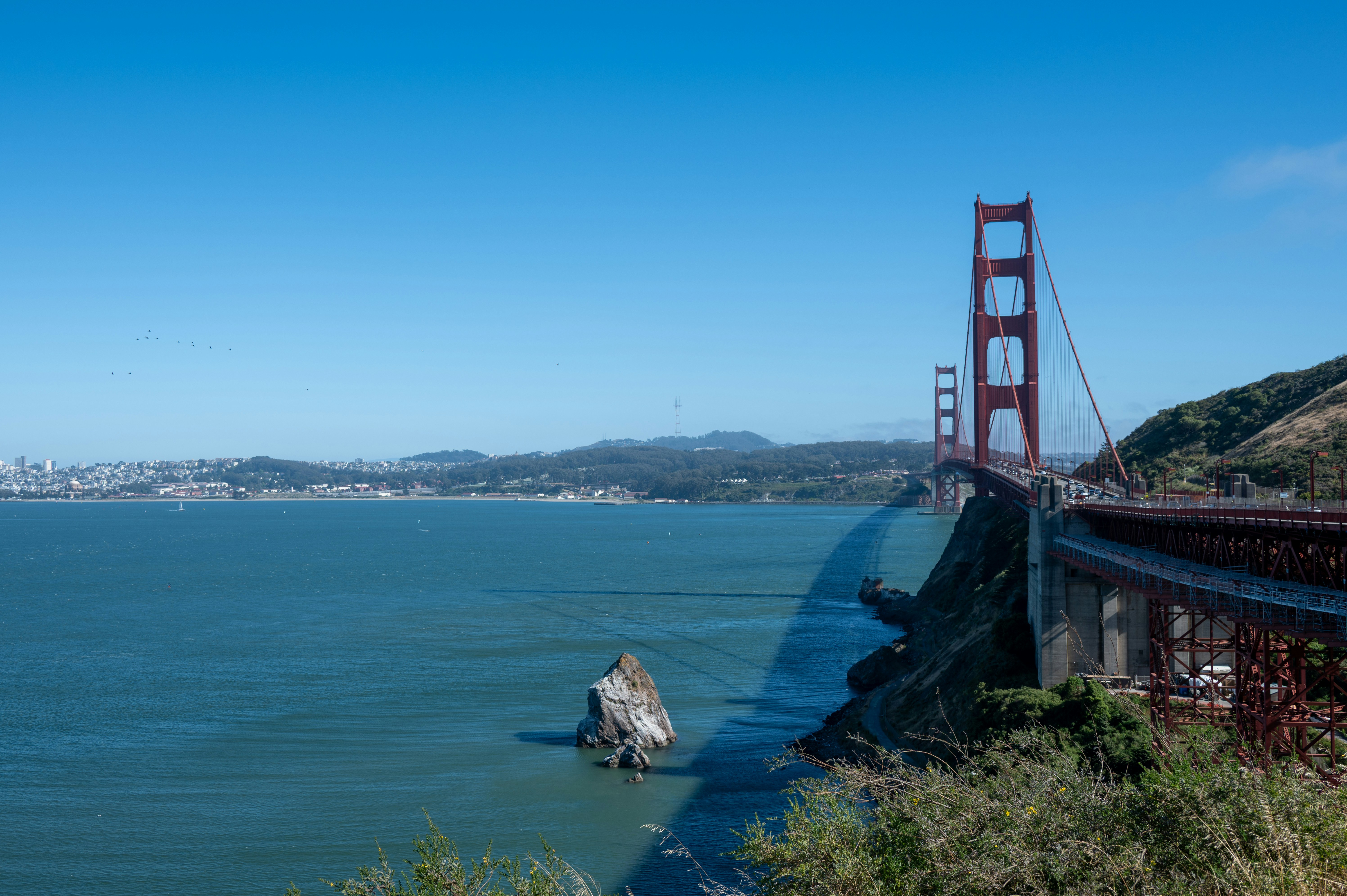 Crimson Span: The Golden Gate Bridge Anchored by a Silent Rock