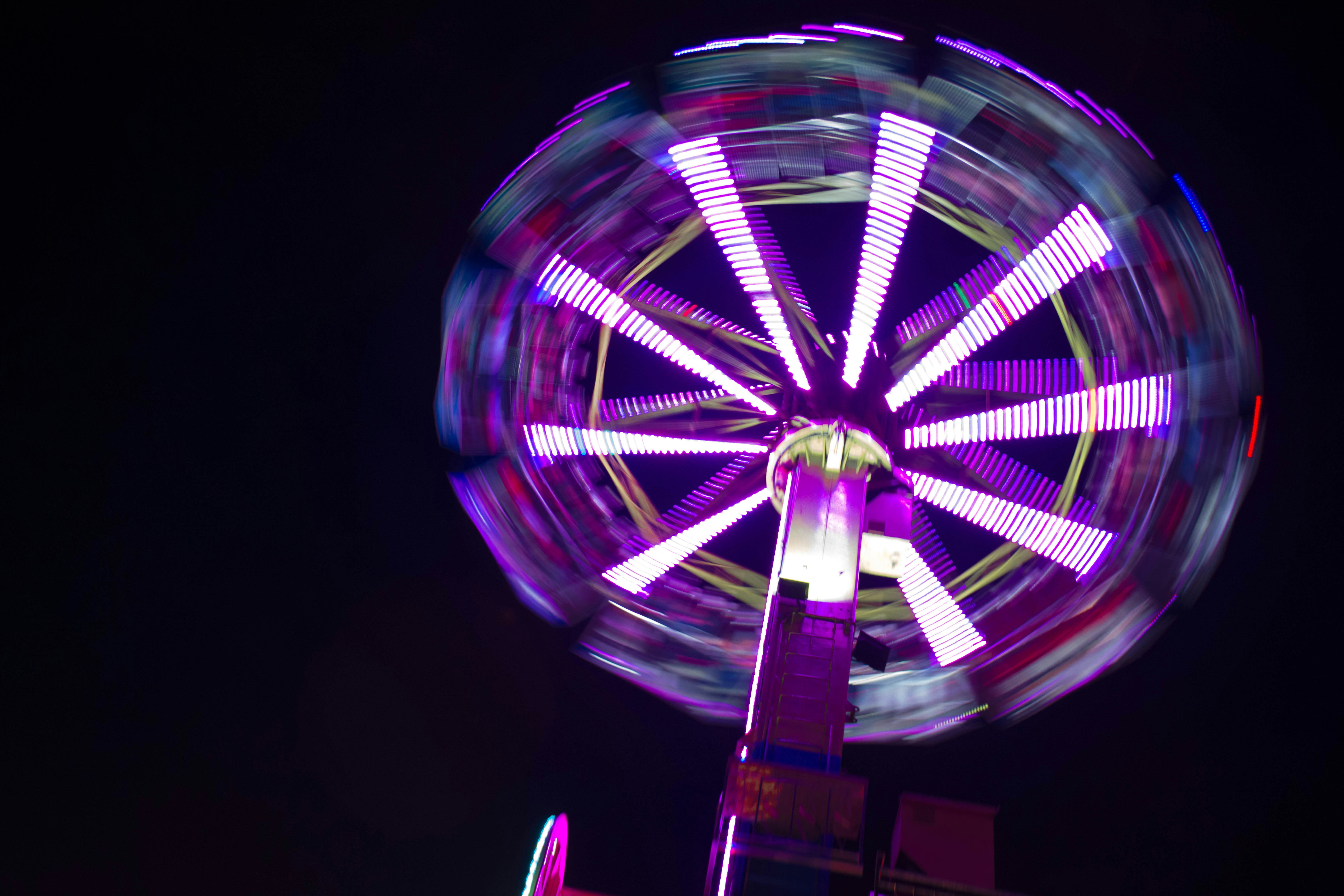 Neon Wheel in Motion: a Nighttime Spin of Pulsing Lights