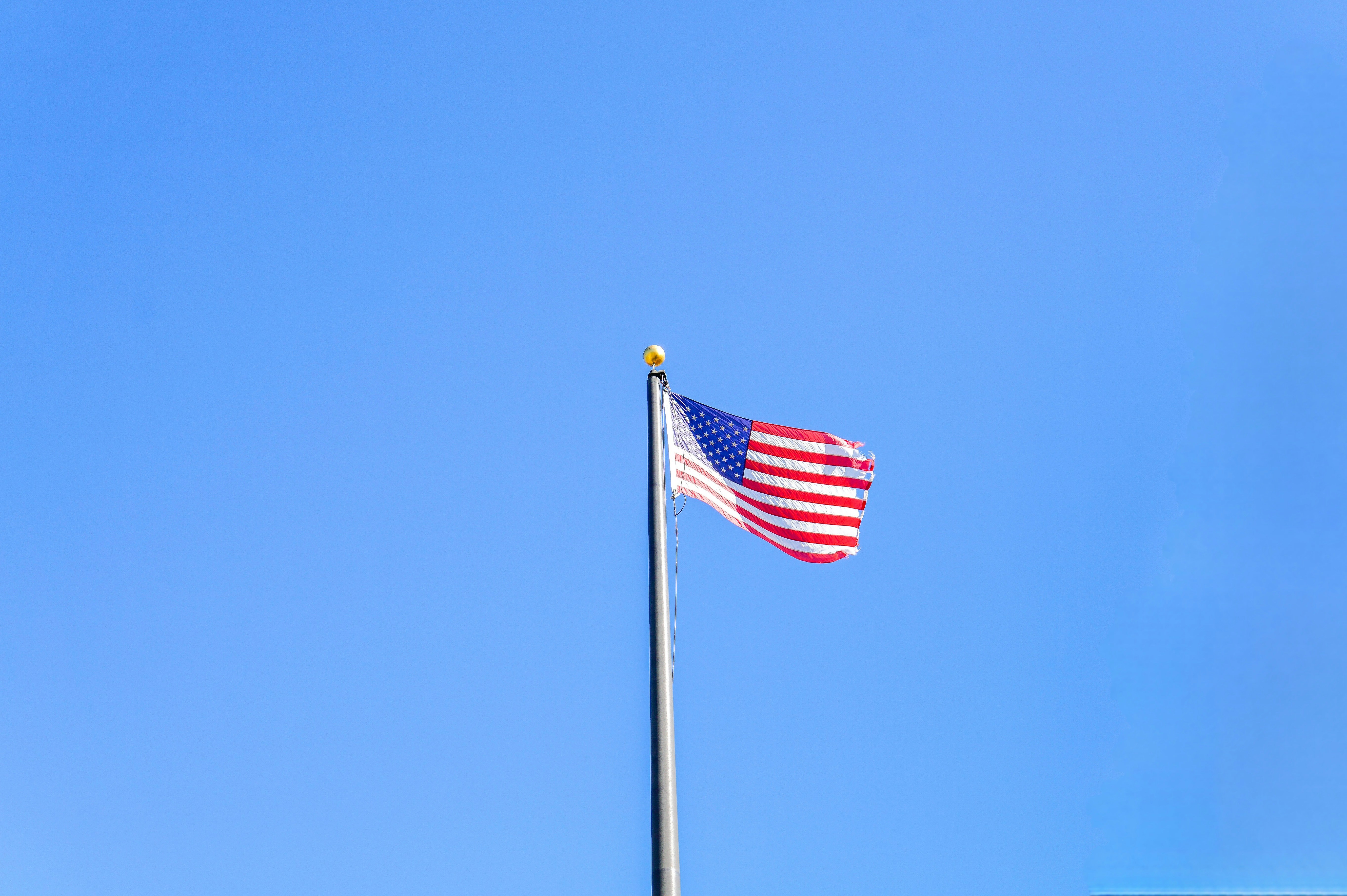 Freedom Ripples: An American Flag Basked in A clear Sky