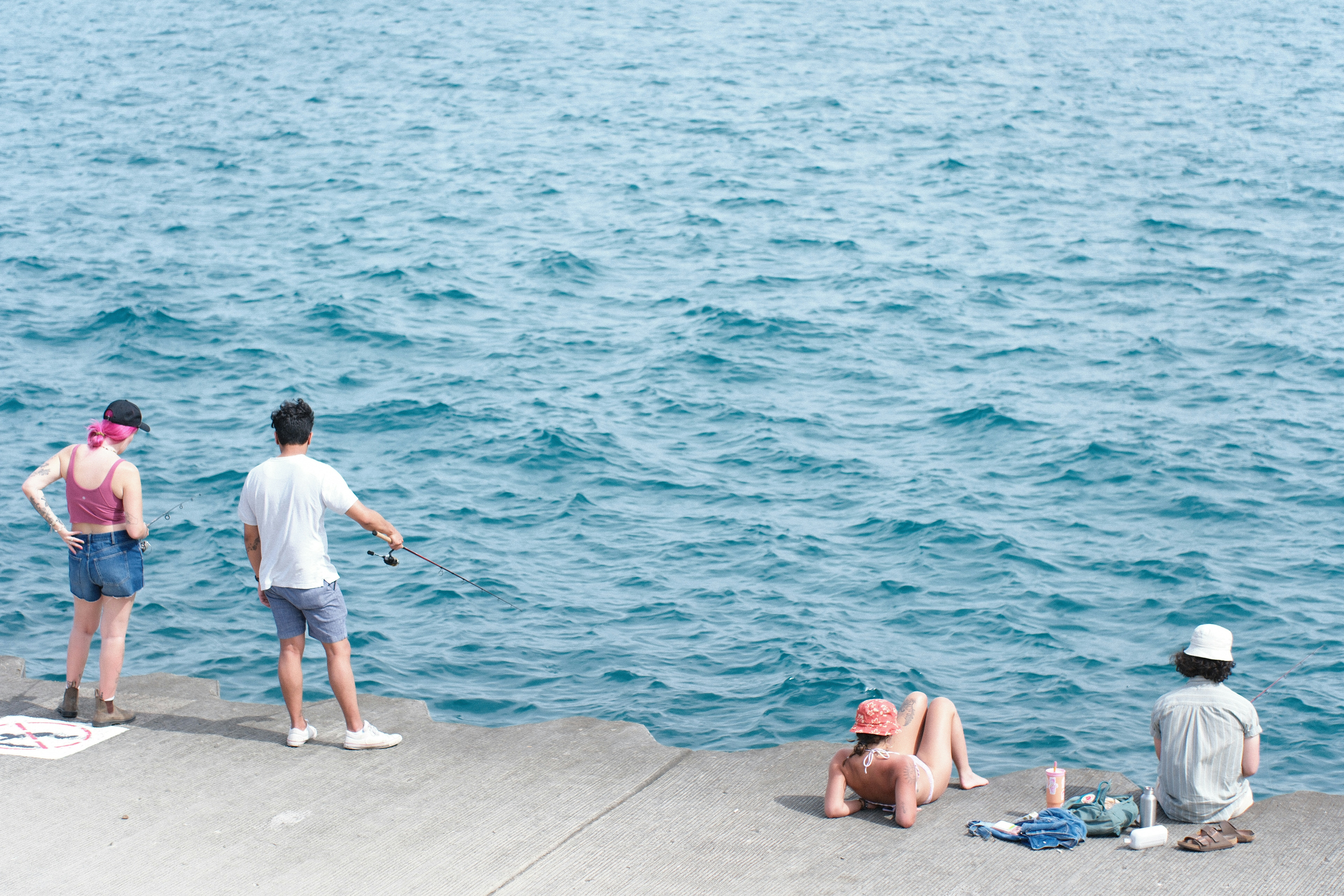 People fishing and relaxing by the ocean