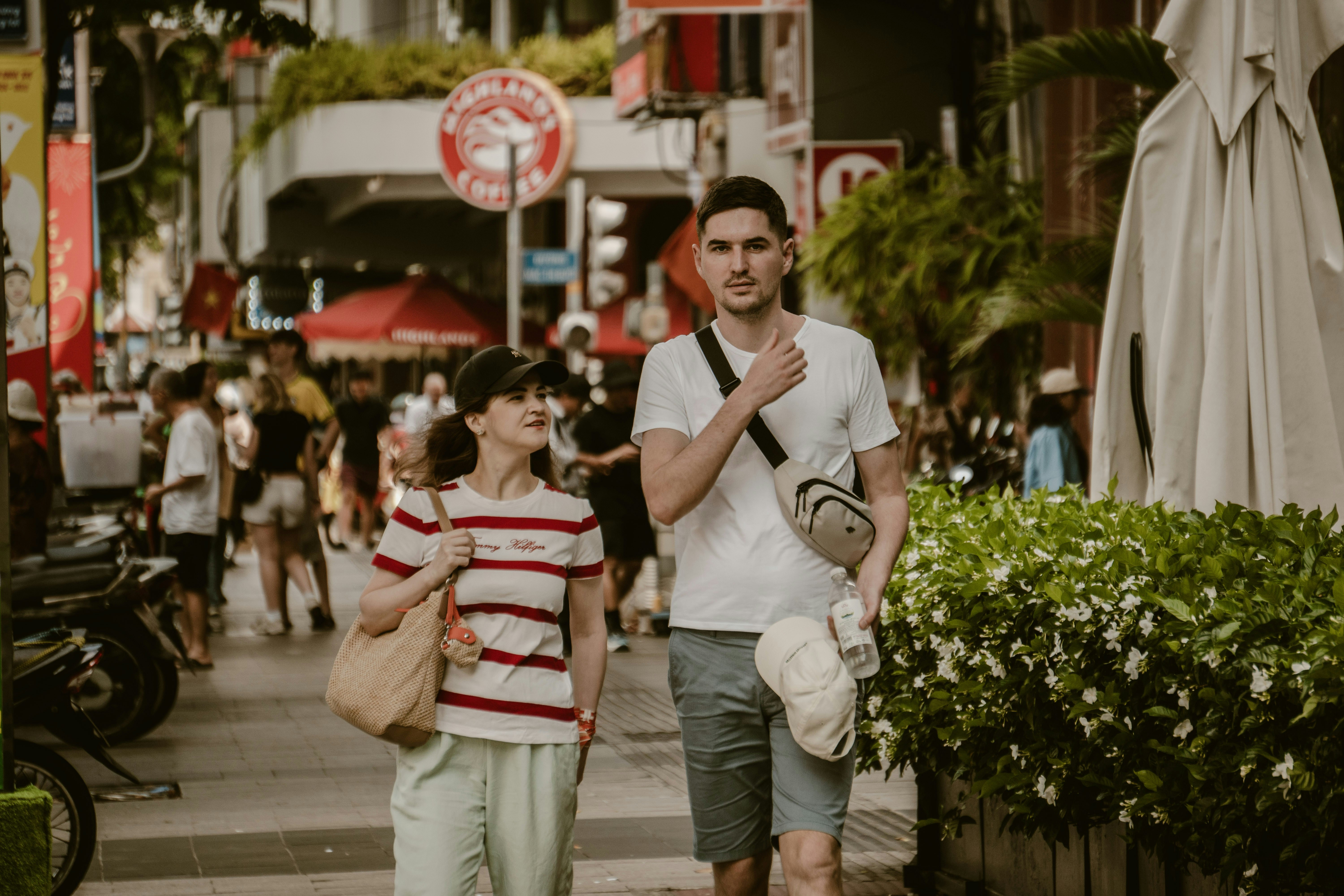 City stroll under café banners: two friends in the urban glow