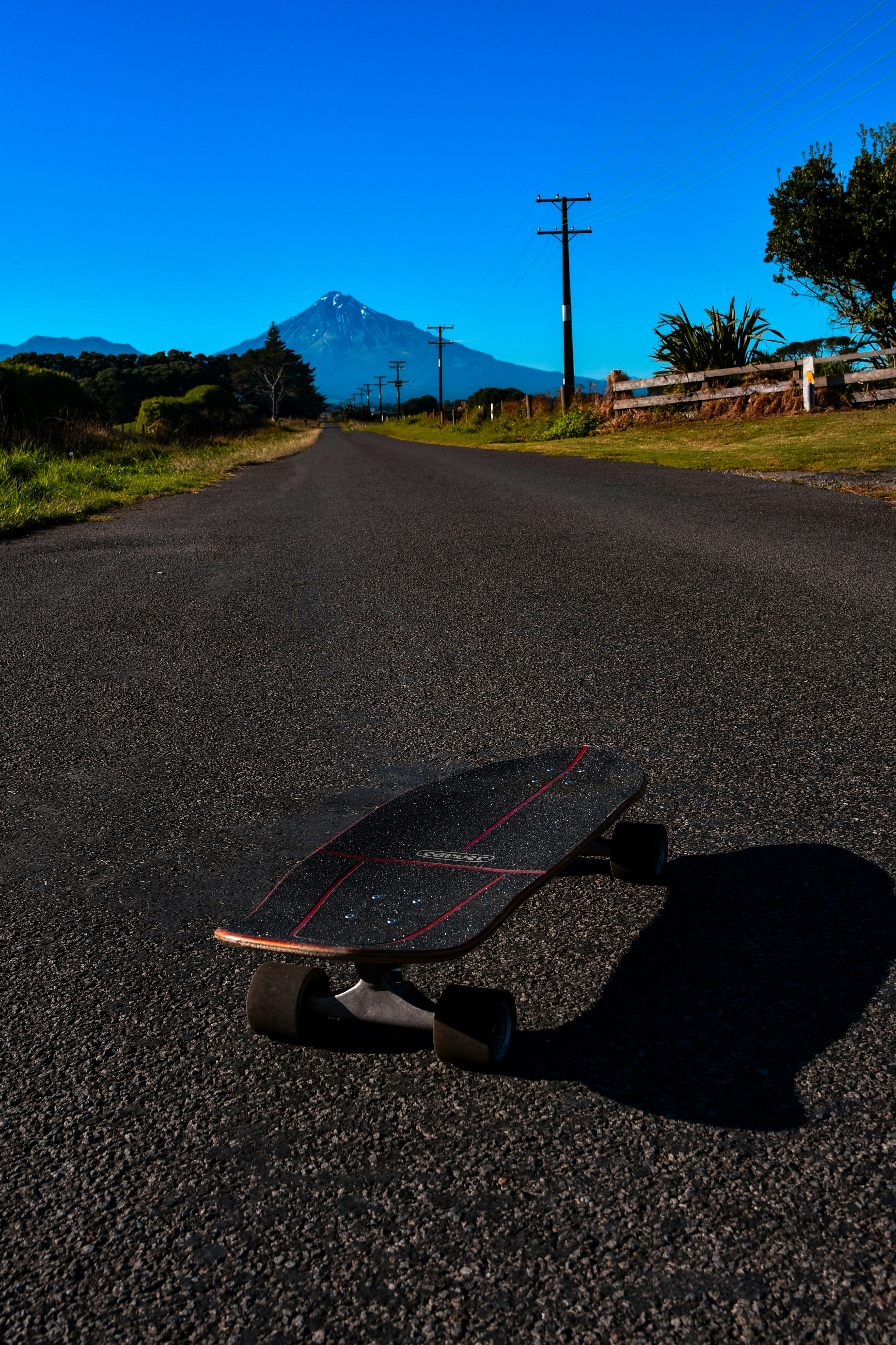 Long Rural Road to the Mountain with a Skateboard in the foreground