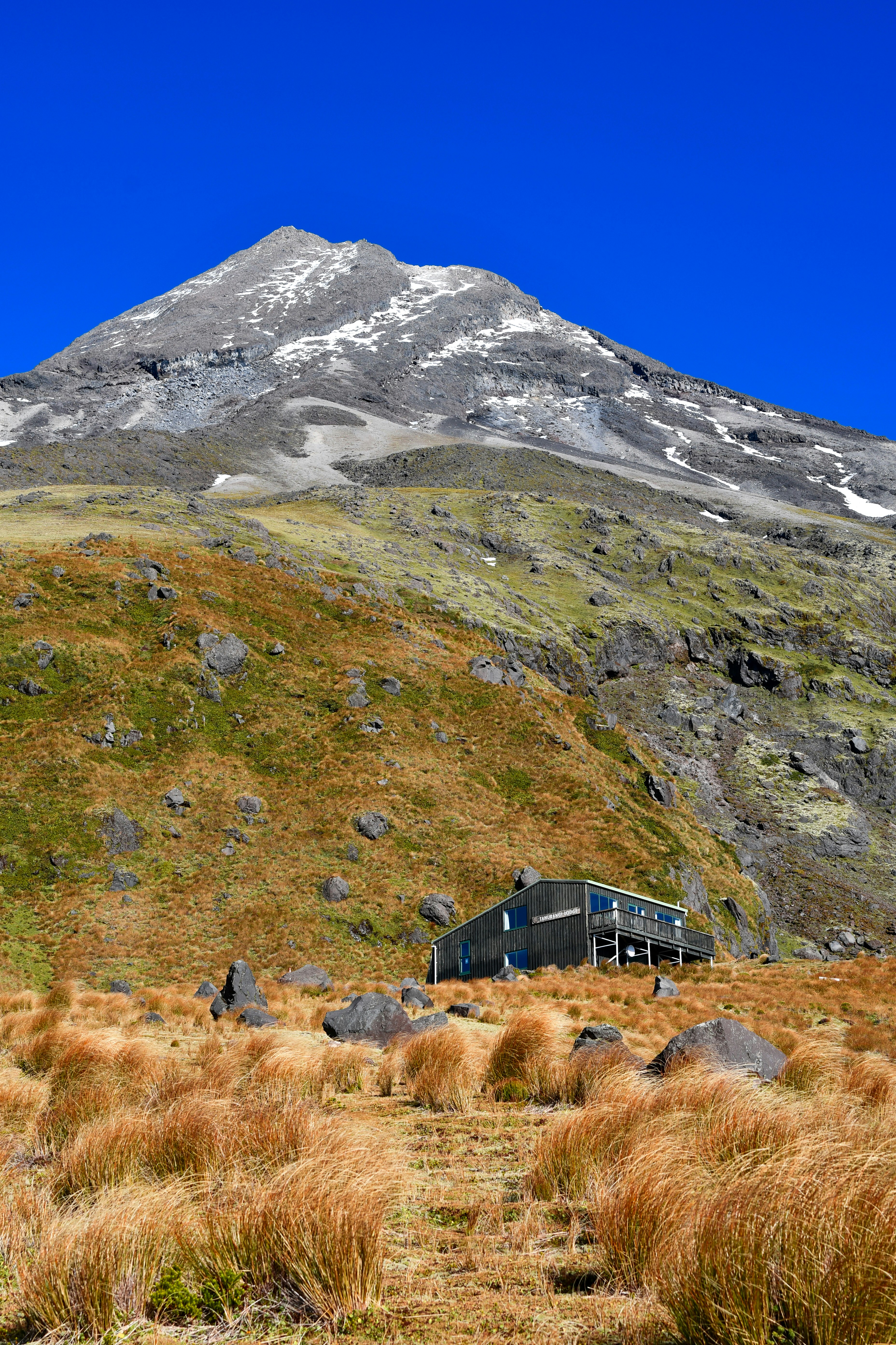 Snowy Peak Overlook: A Mountain Hut Amid Open Grassland