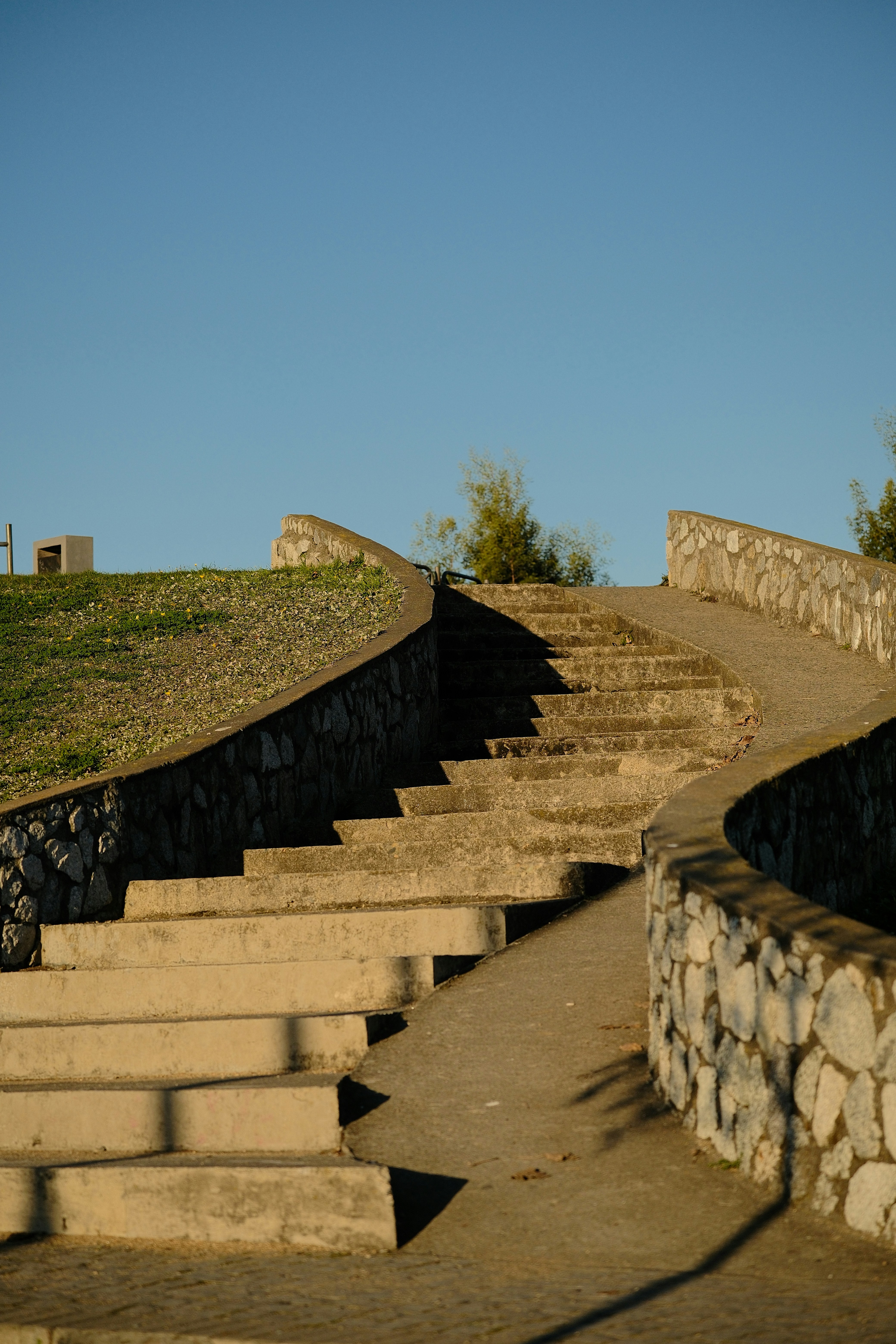 Sunlit descent: a terraced stone staircase curves toward the horizon