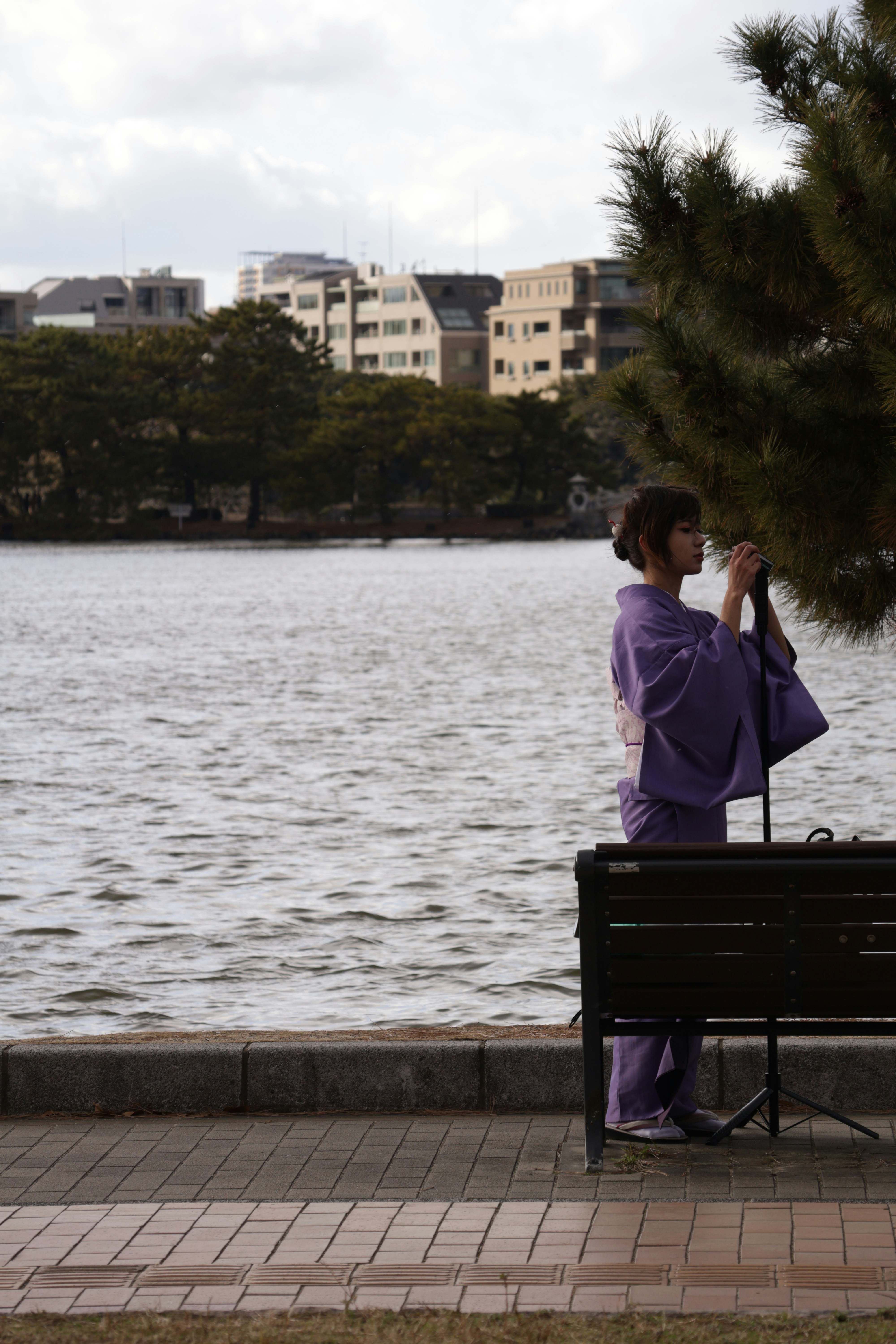 Purple-clad musician by the riverside, capturing a quiet performance
