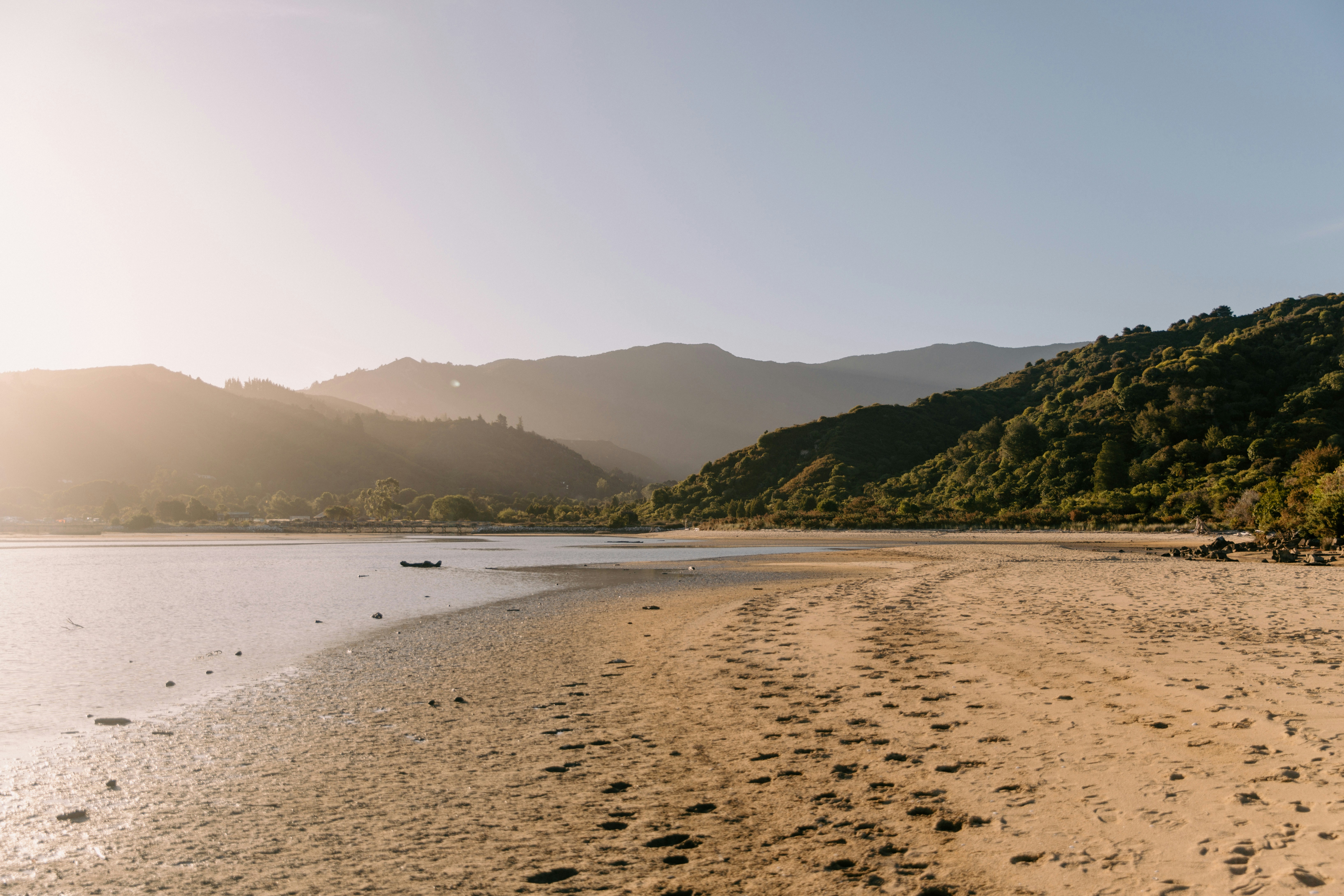 Sunlit Shoreline at Distant Hills