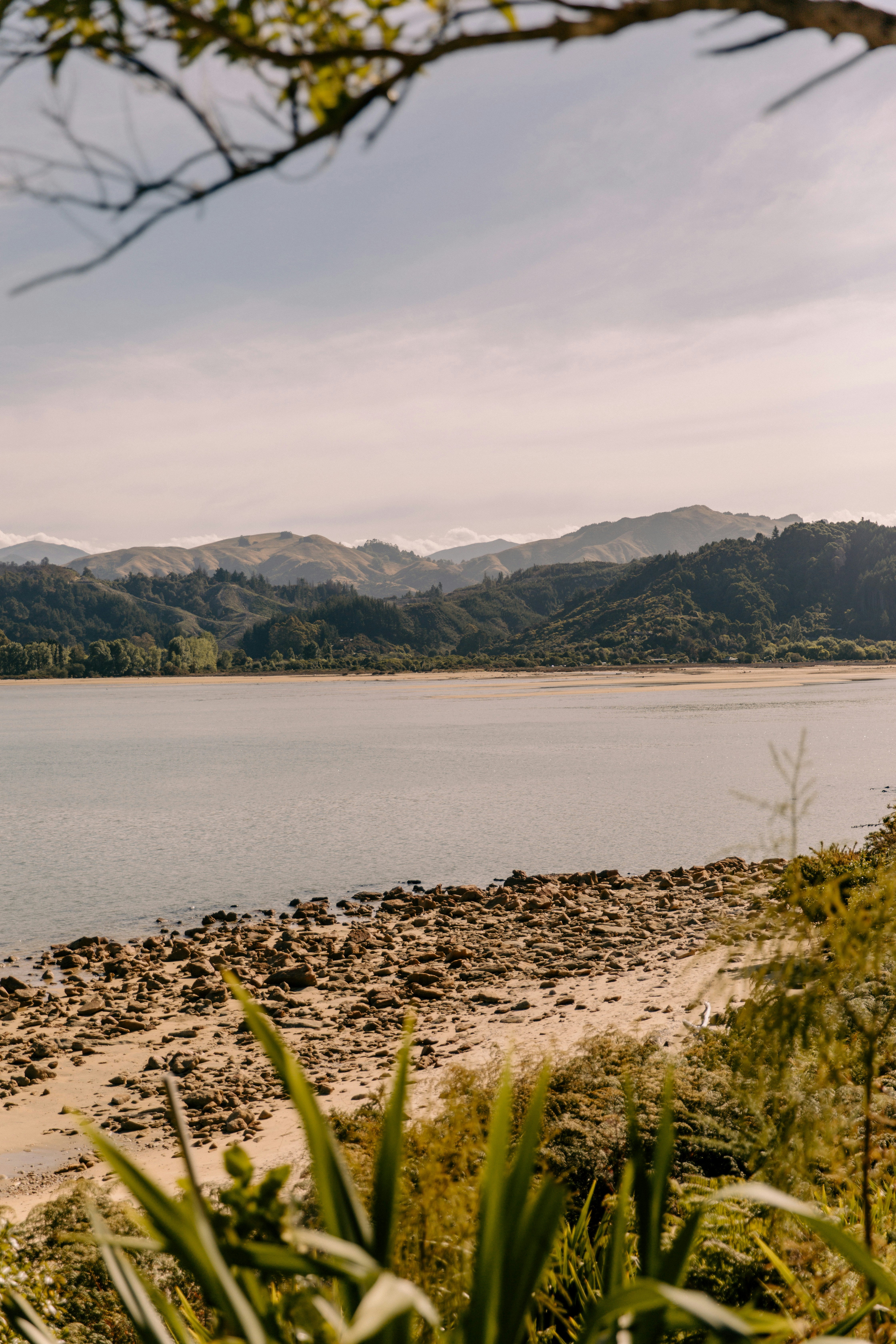 Quiet shoreline arc: sunlit hills and a framed river