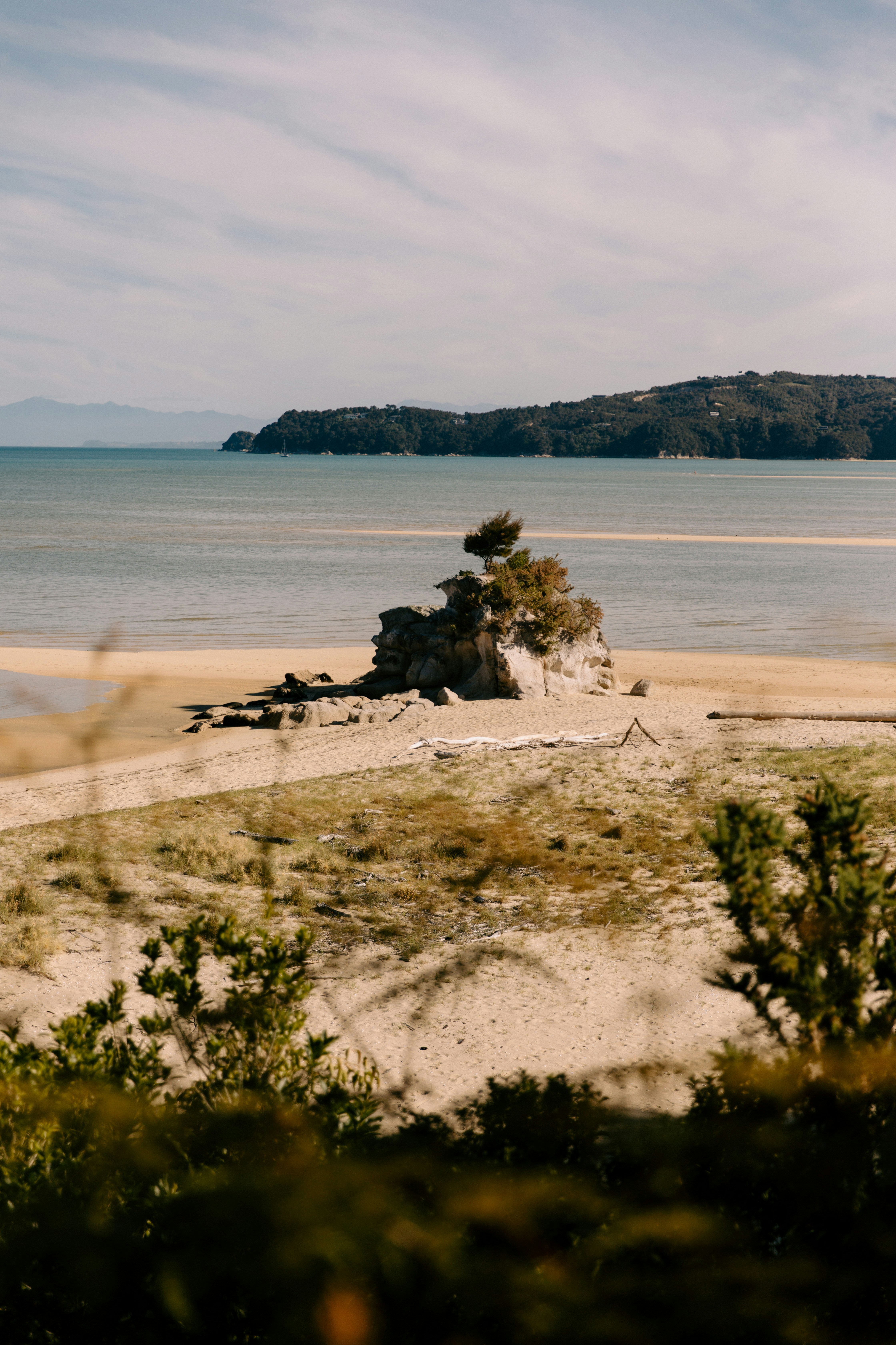 Rock among the shoreline: a quiet coastal promontory framed by ocean and distant headlands