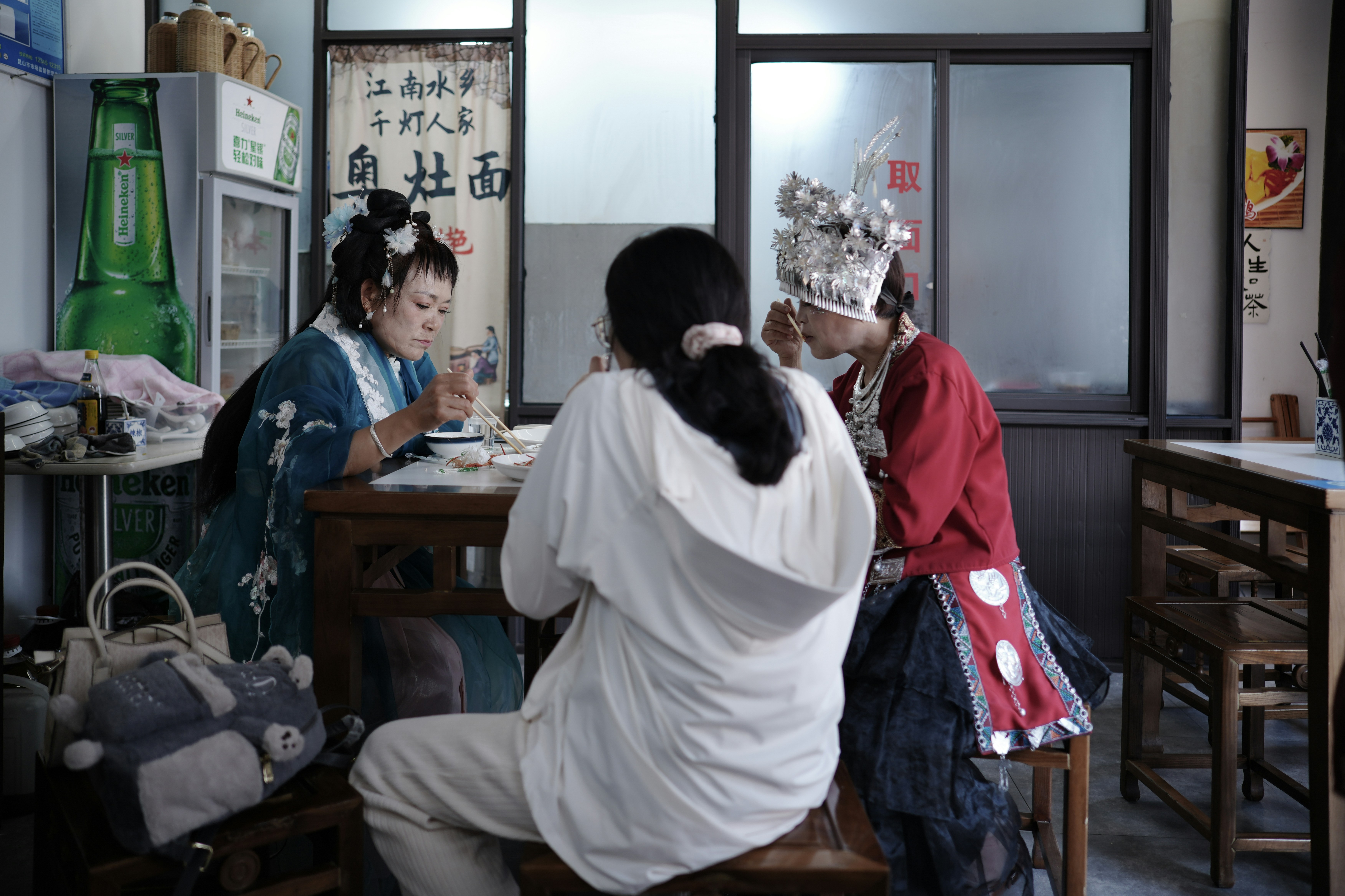 Three Actors at a Cozy Kitchen Table in Traditional Attire