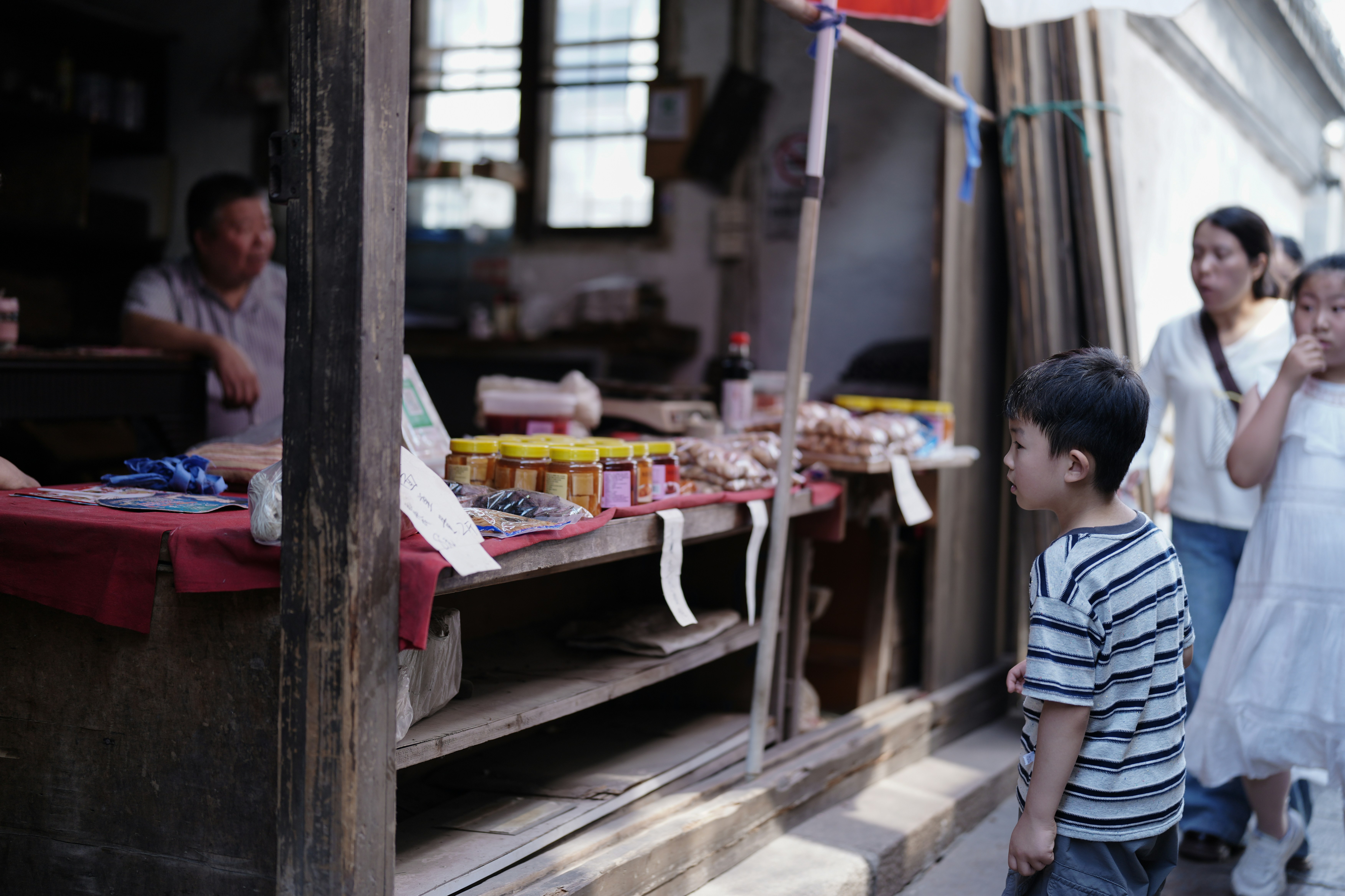 Jeune garçon observant un étal de rue avec un vendeur. photo – Image ...