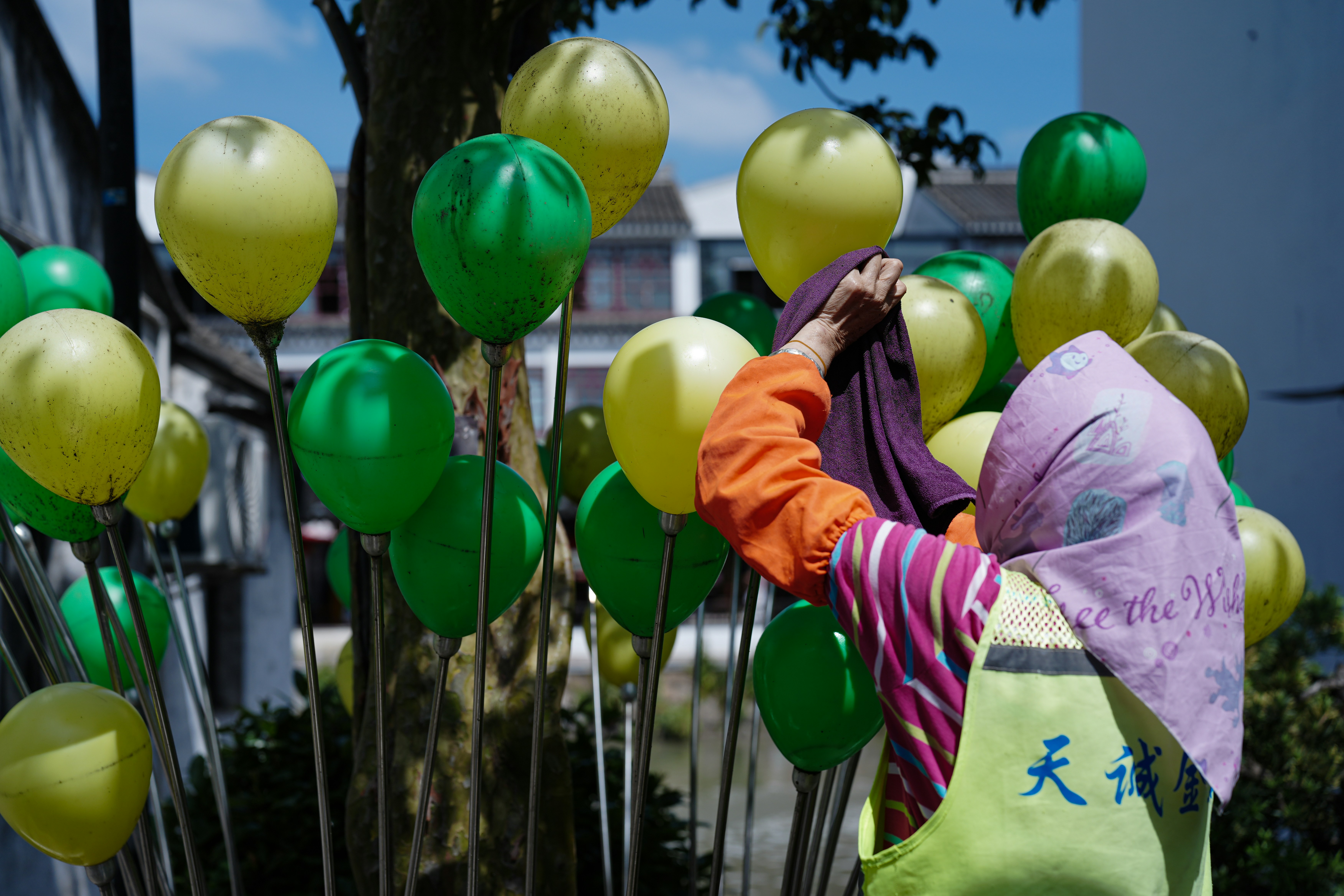 Colorful Balloons Meet a Person shielding with a Wrapped Hood